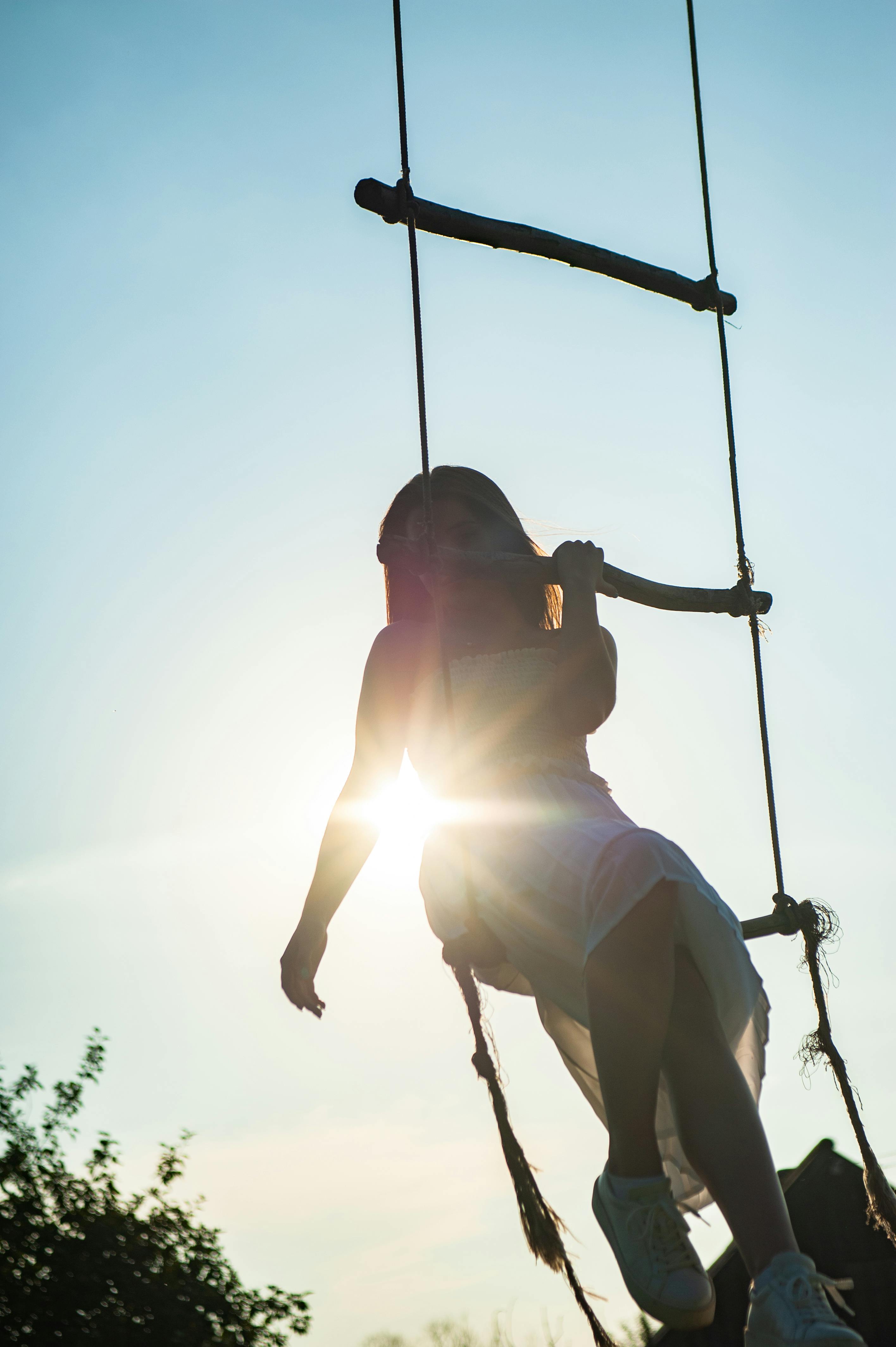 Woman Sitting on Hanging Ladder · Free Stock Photo