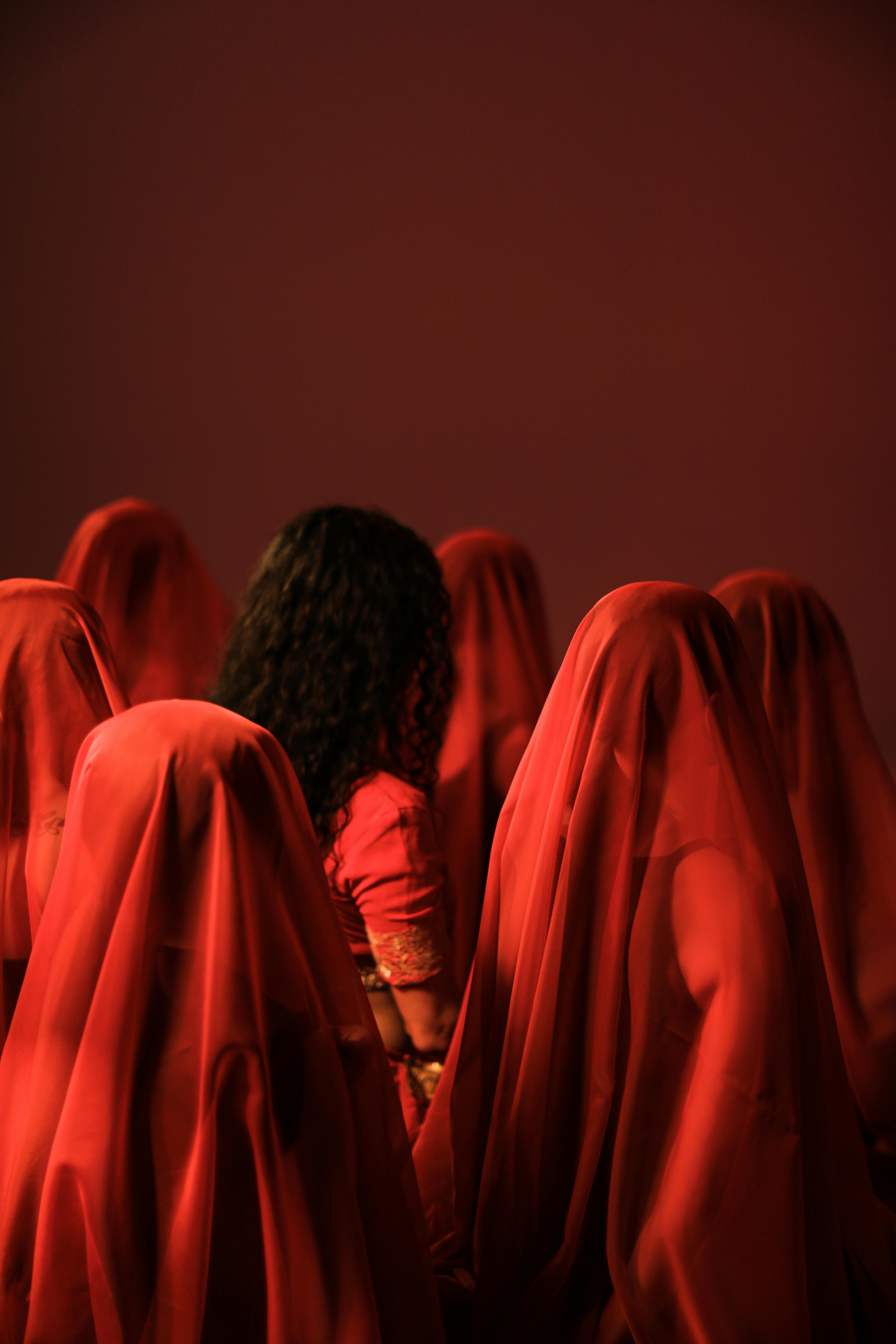 Brunette among Women in Red Veils · Free Stock Photo