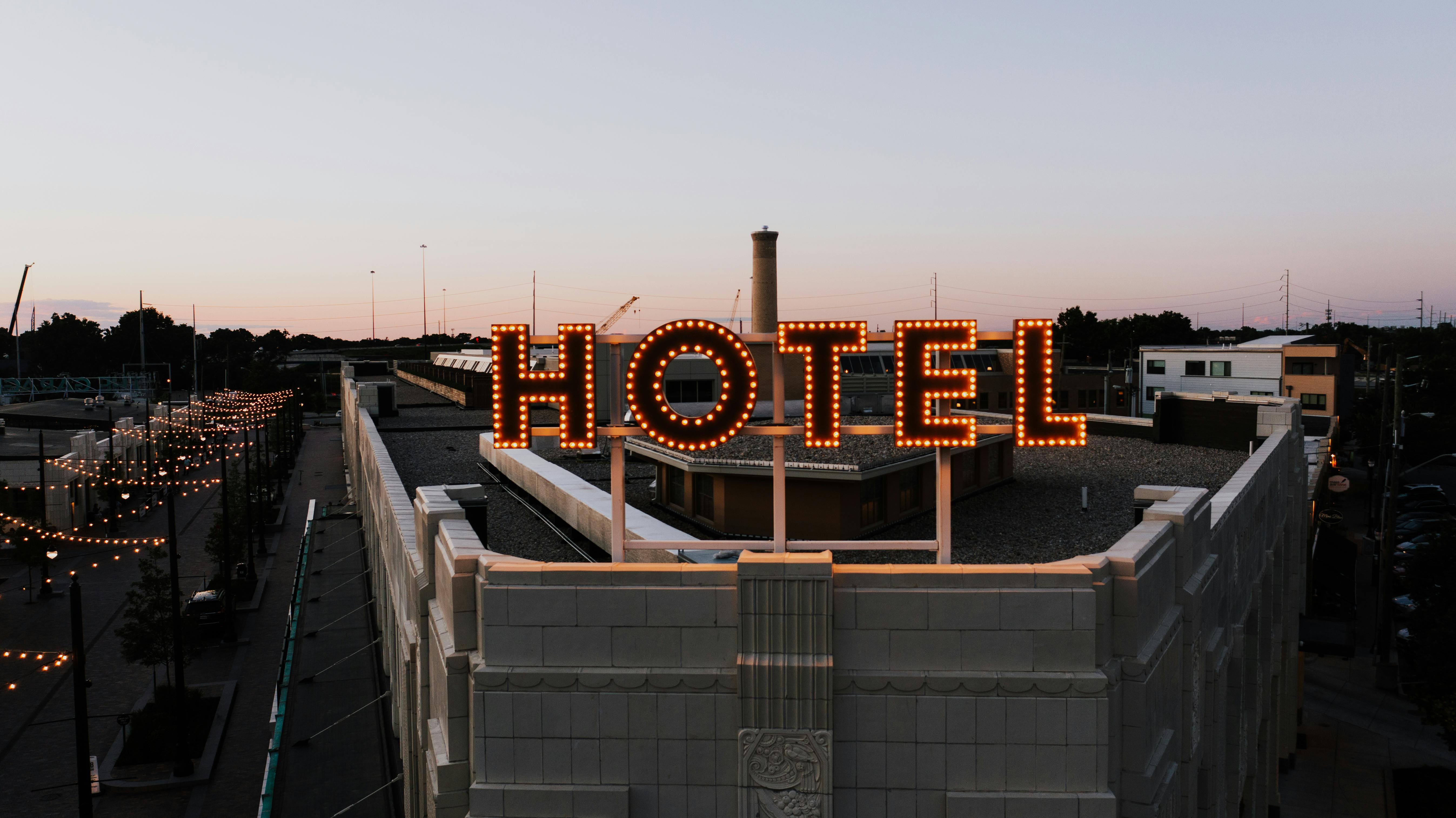 A Signage with Lights Placed on Top of a Hotel Building · Free Stock Photo