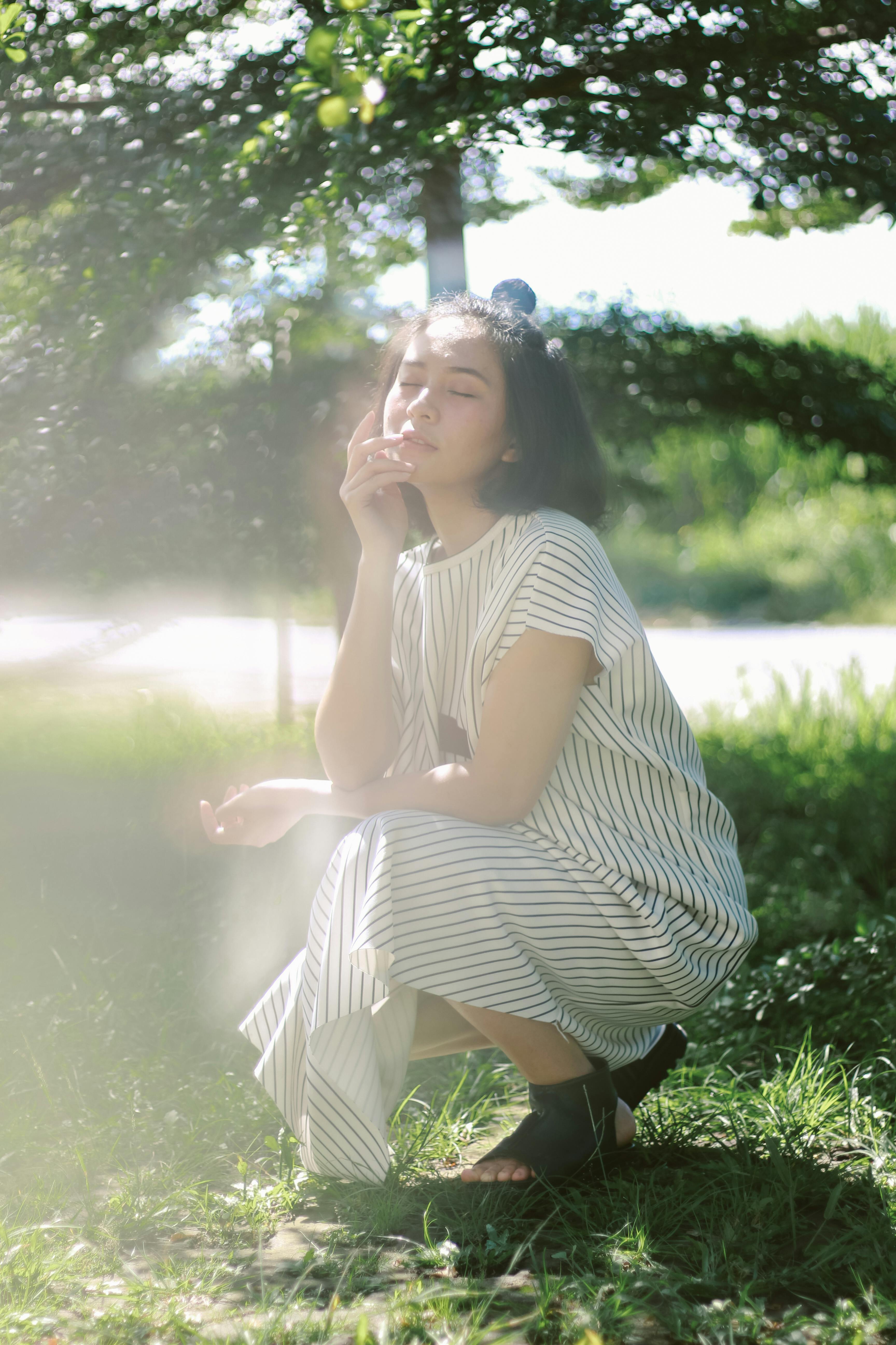 Woman Crouching near Tree · Free Stock Photo