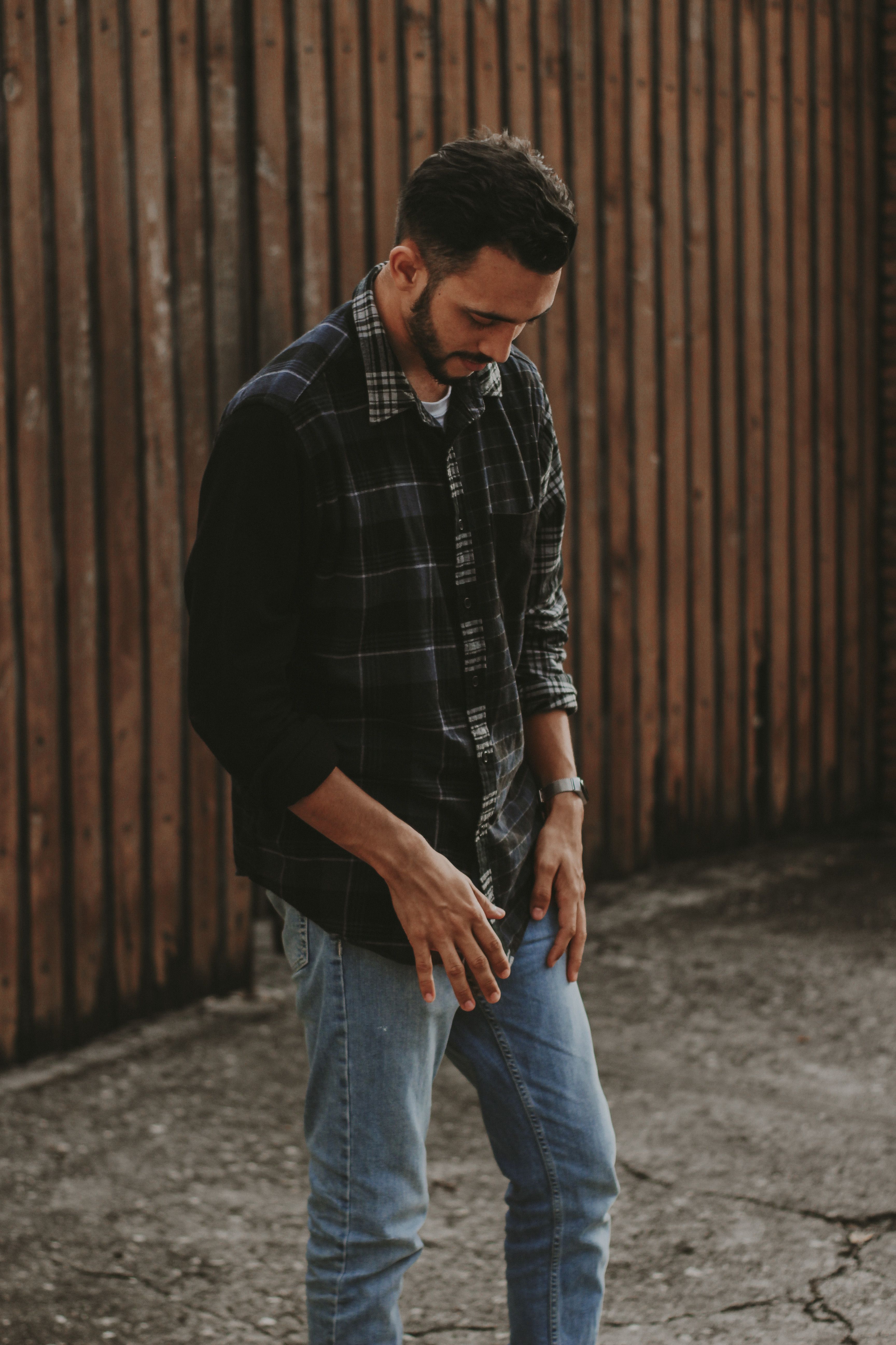 A Man Standing while Leaning on a Brick Wall · Free Stock Photo