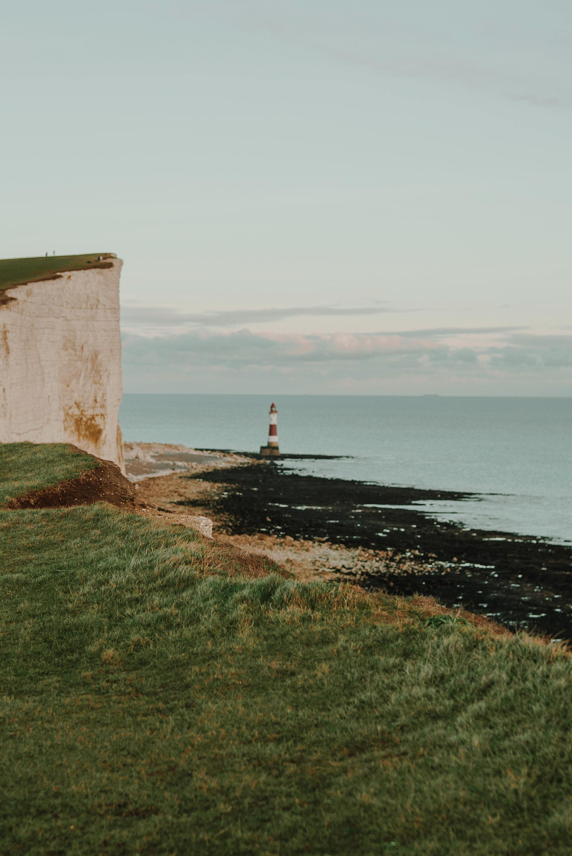 Photo of Blue and White Painted Lighthouse Near the Beach · Free Stock ...