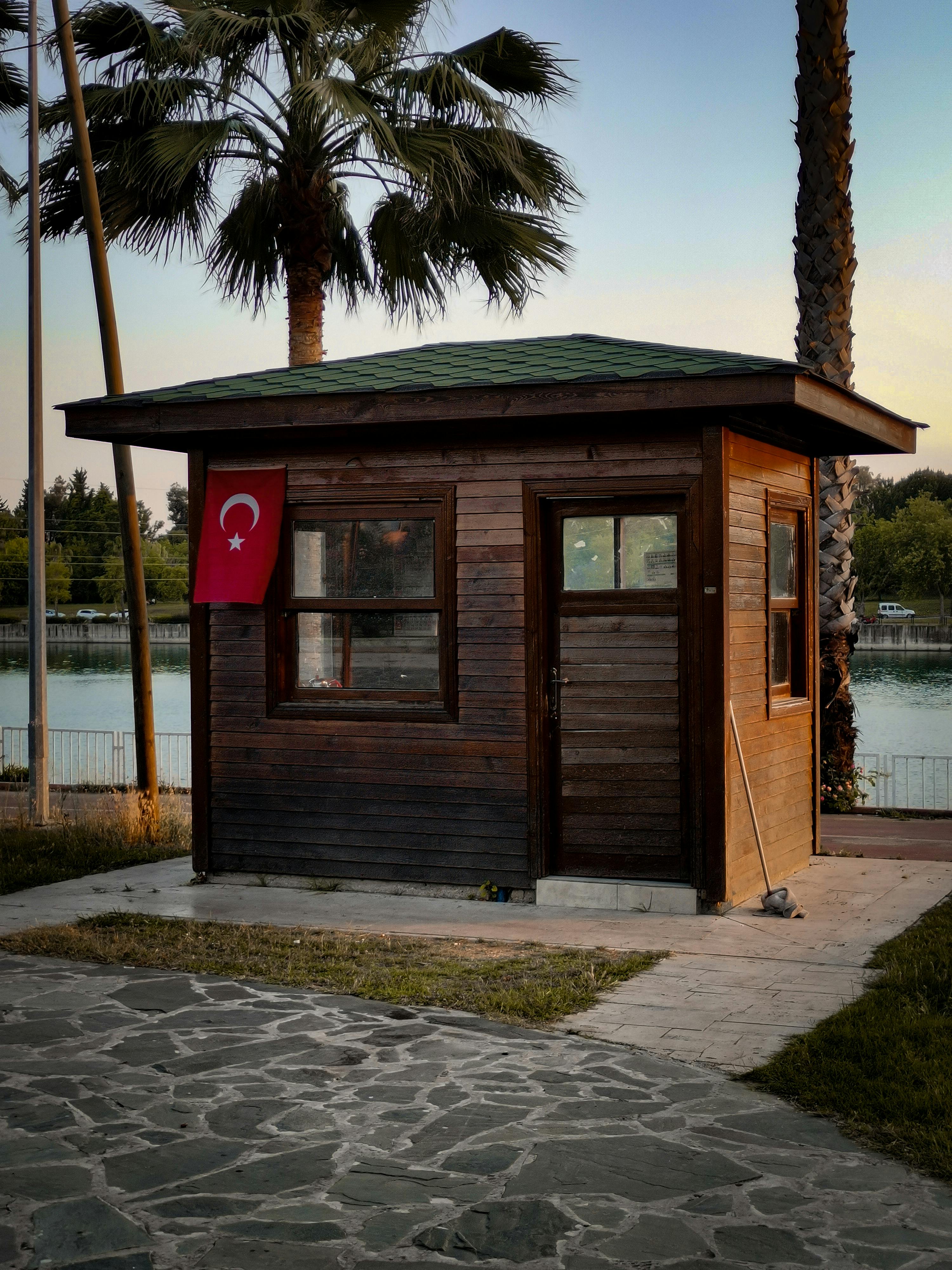 Wooden Hut with a Turkish Flag Under Palm Trees · Free Stock Photo