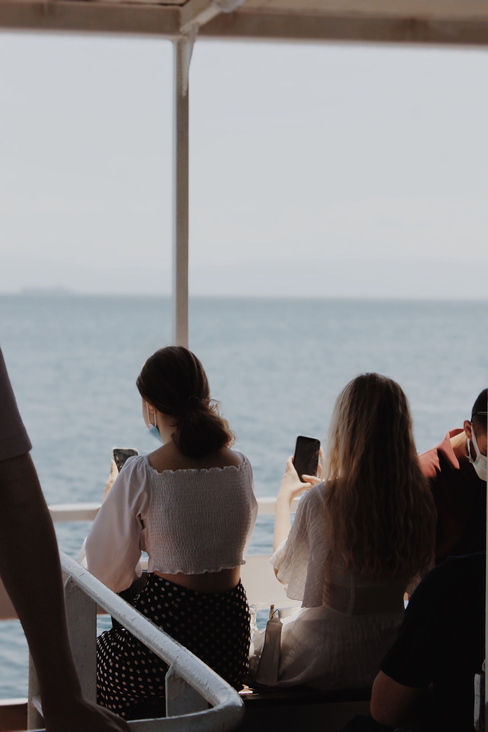 Woman in Brown Coat Sitting on Seaside · Free Stock Photo