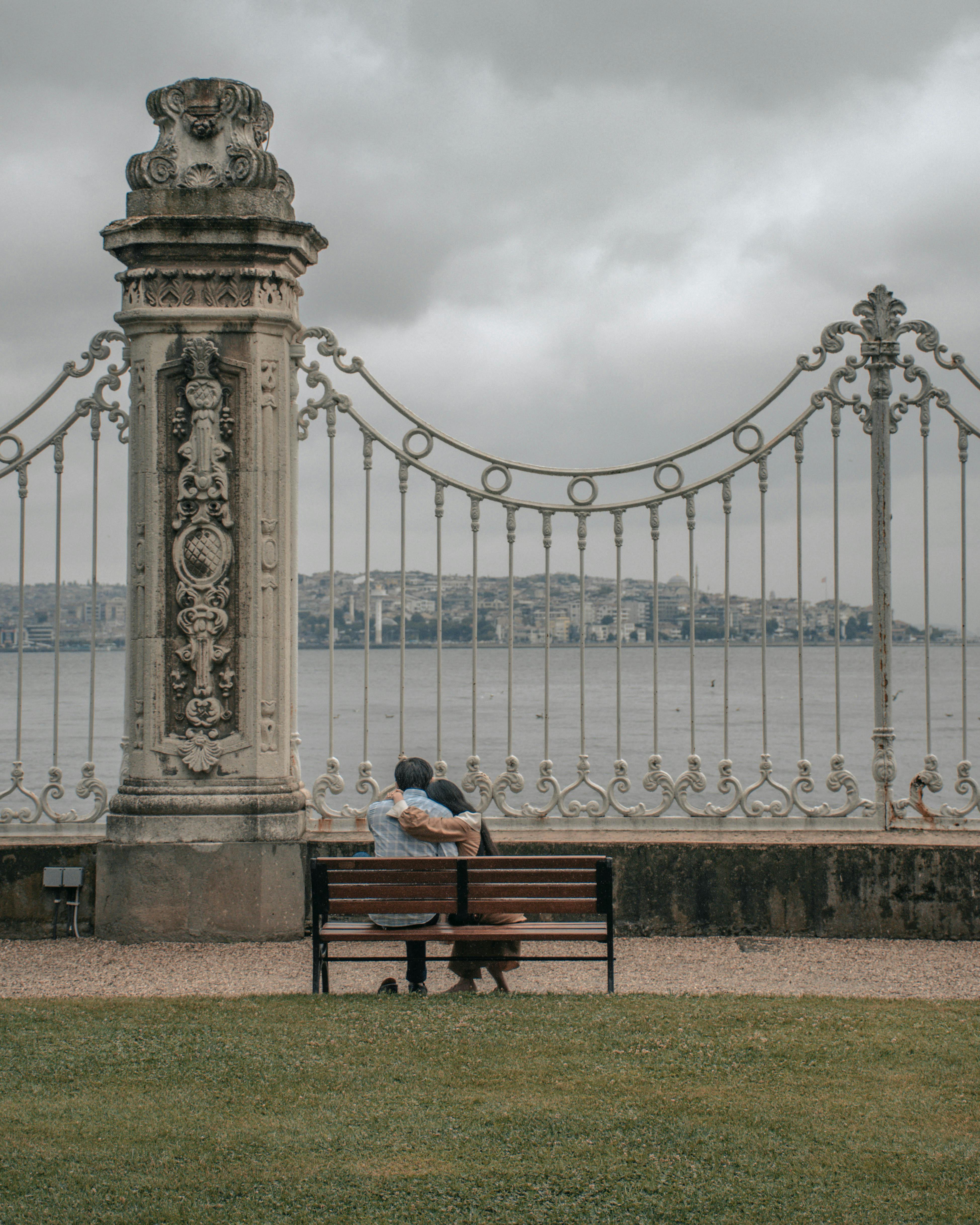 Couple Sitting on Bench Near the Iron Fence of Dolmabahçe Palace in ...