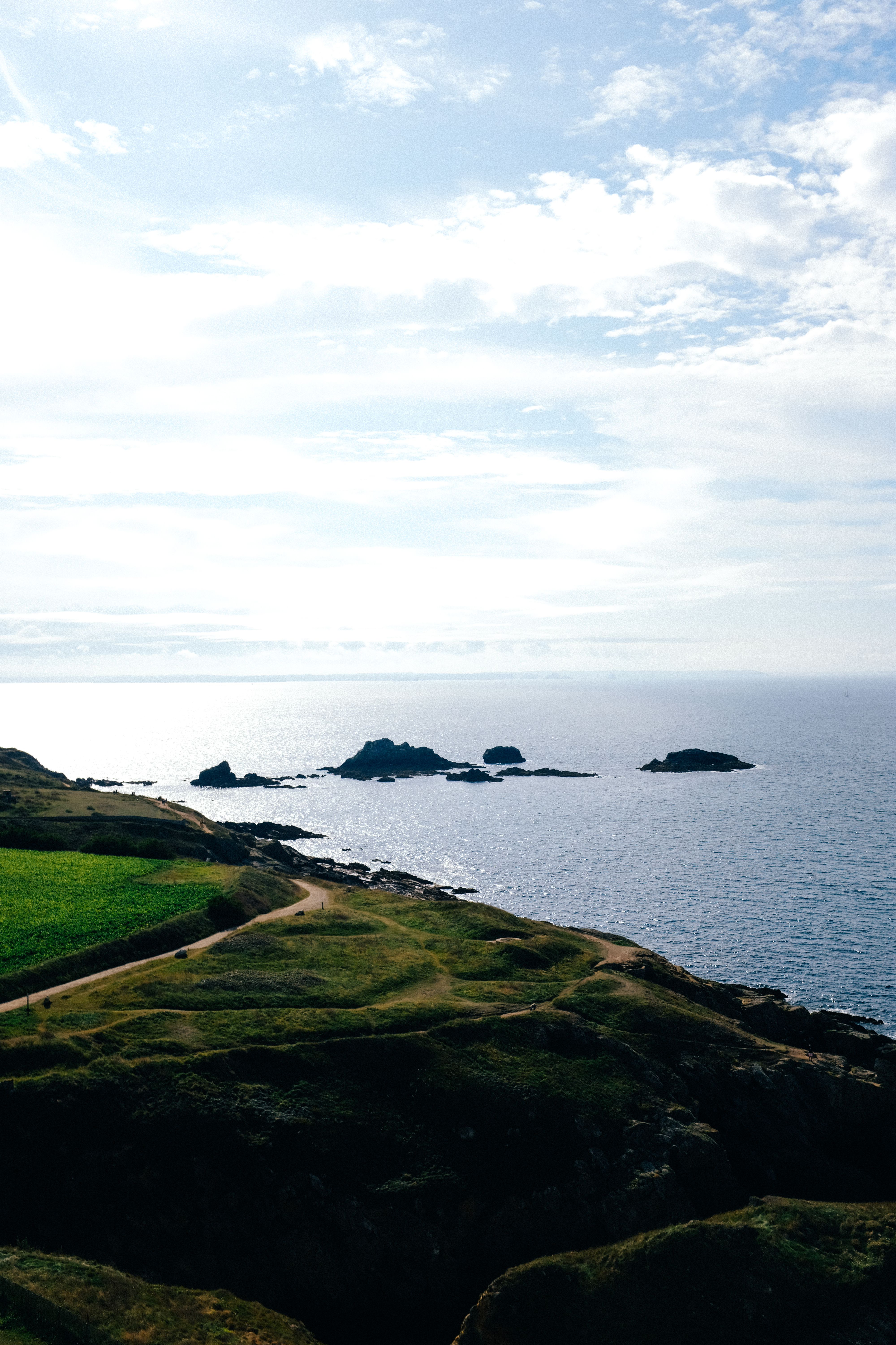 Grass Filled Cliff Near Body of Water · Free Stock Photo
