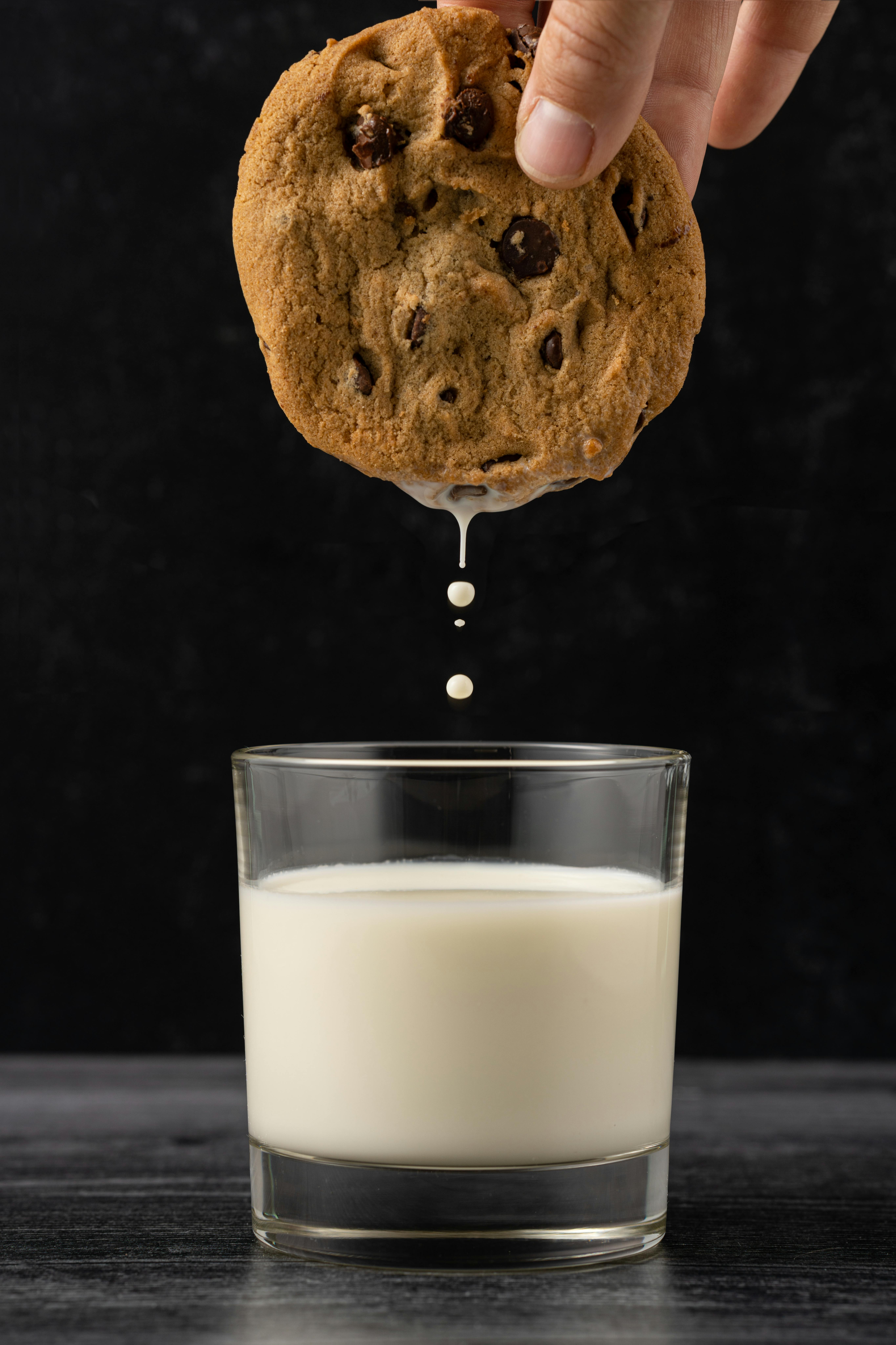 Photo of a Person's Hand Dipping a Cookie in a Glass of Milk · Free ...