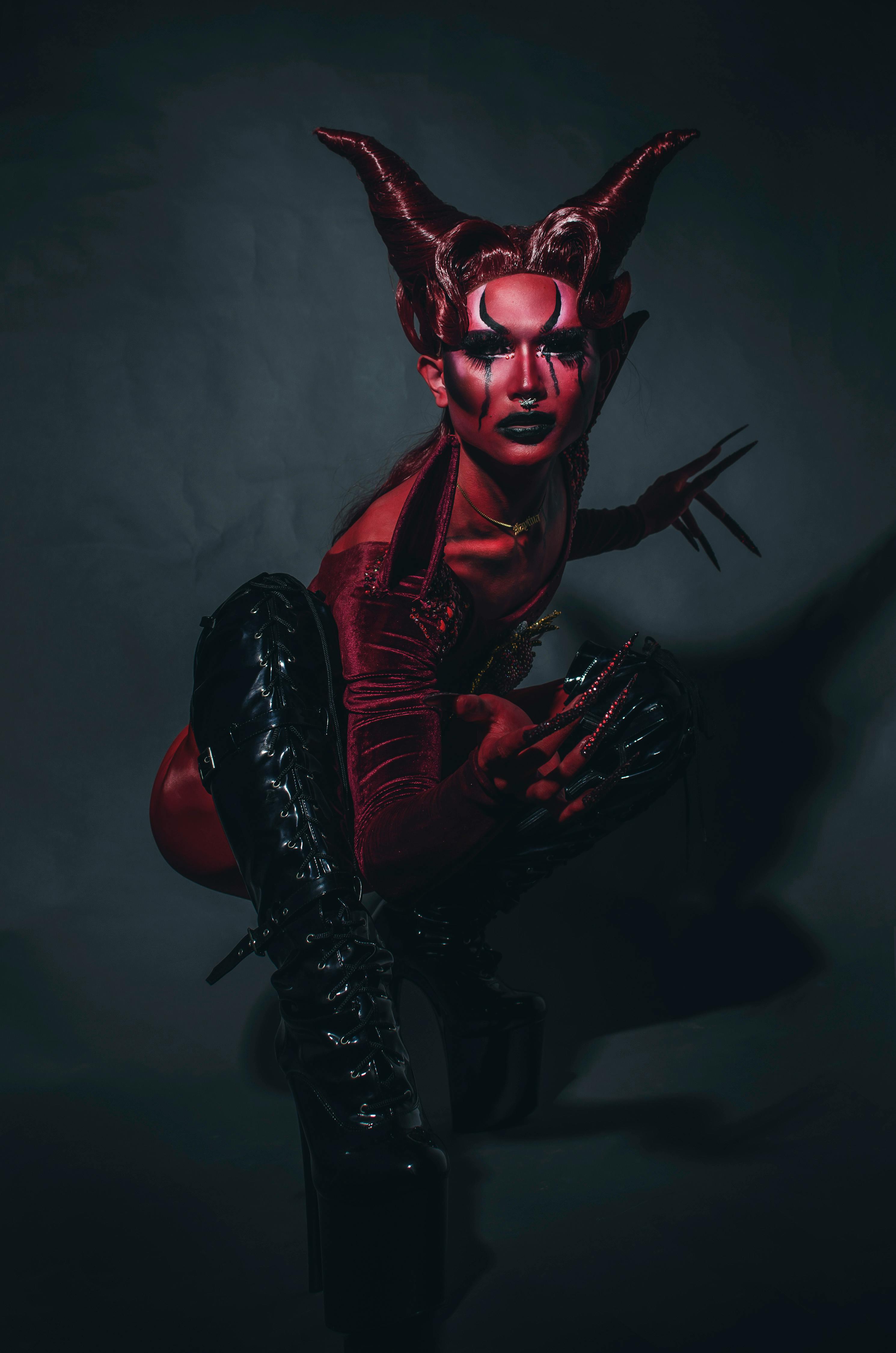 Crouching Fashion Model Disguised as Black and Red Devil · Free Stock Photo