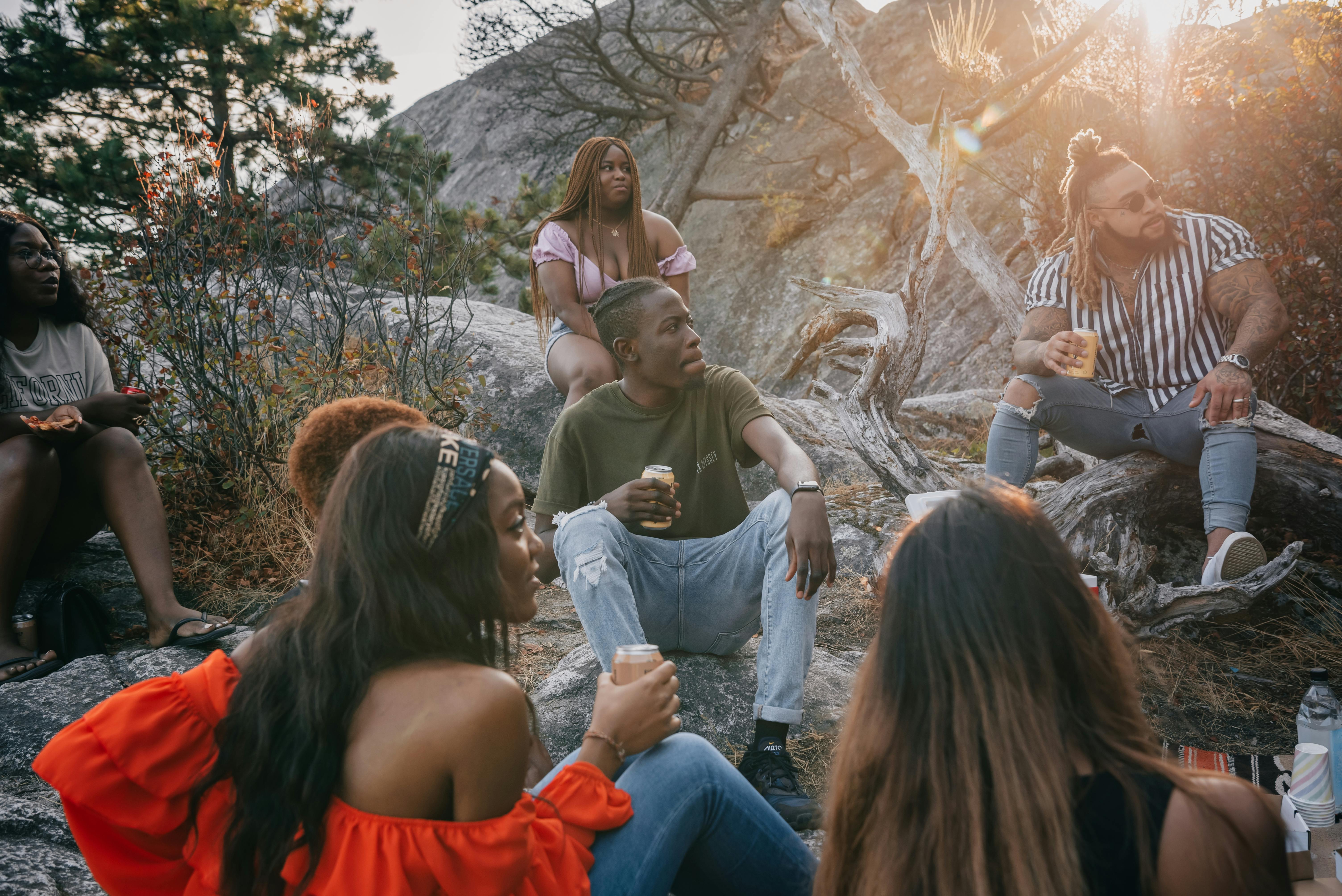People Sitting on Big Rocks while Drinking Together · Free Stock Photo