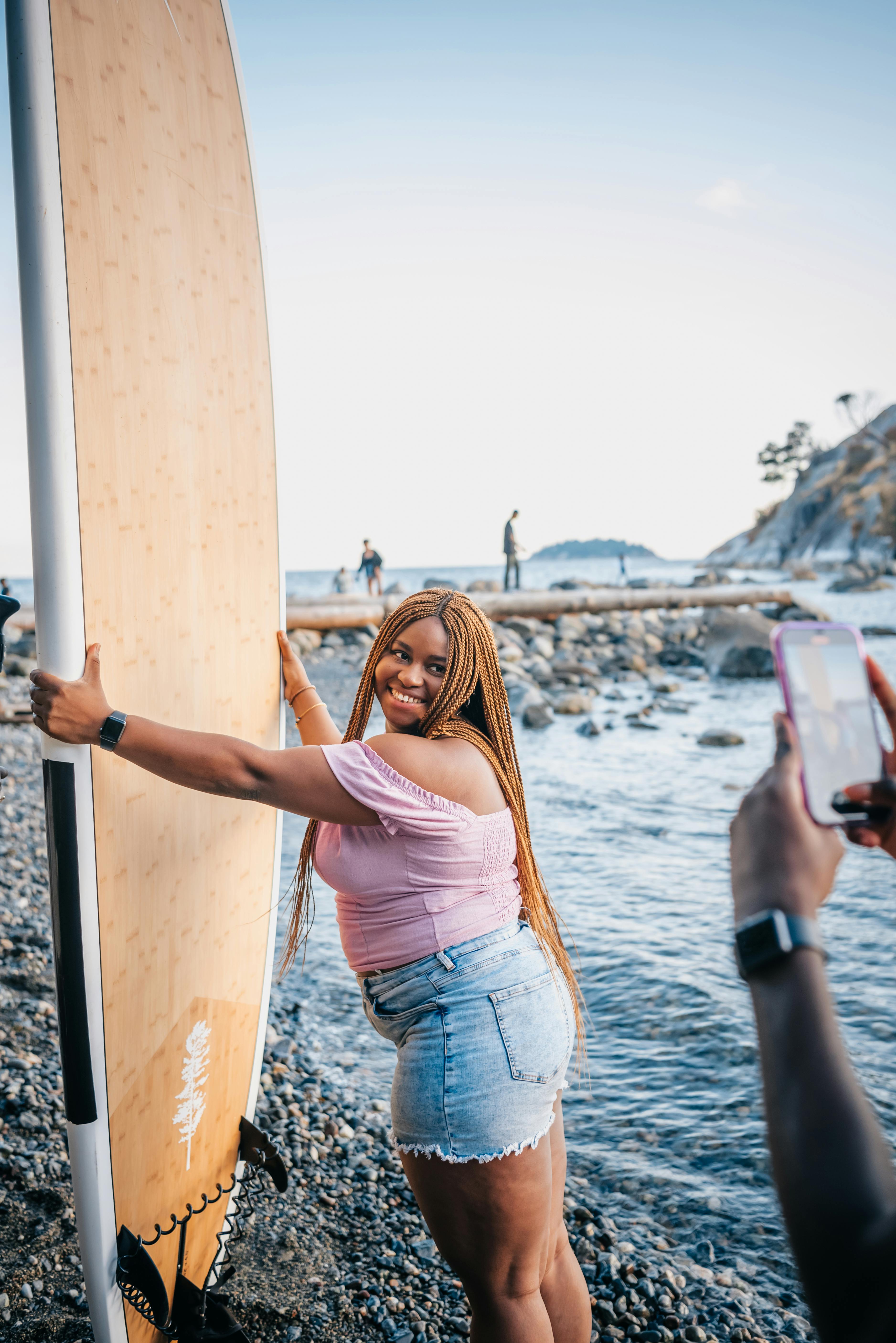 Woman Posing for a Picture and Holding a Surfboard on a Beach · Free ...