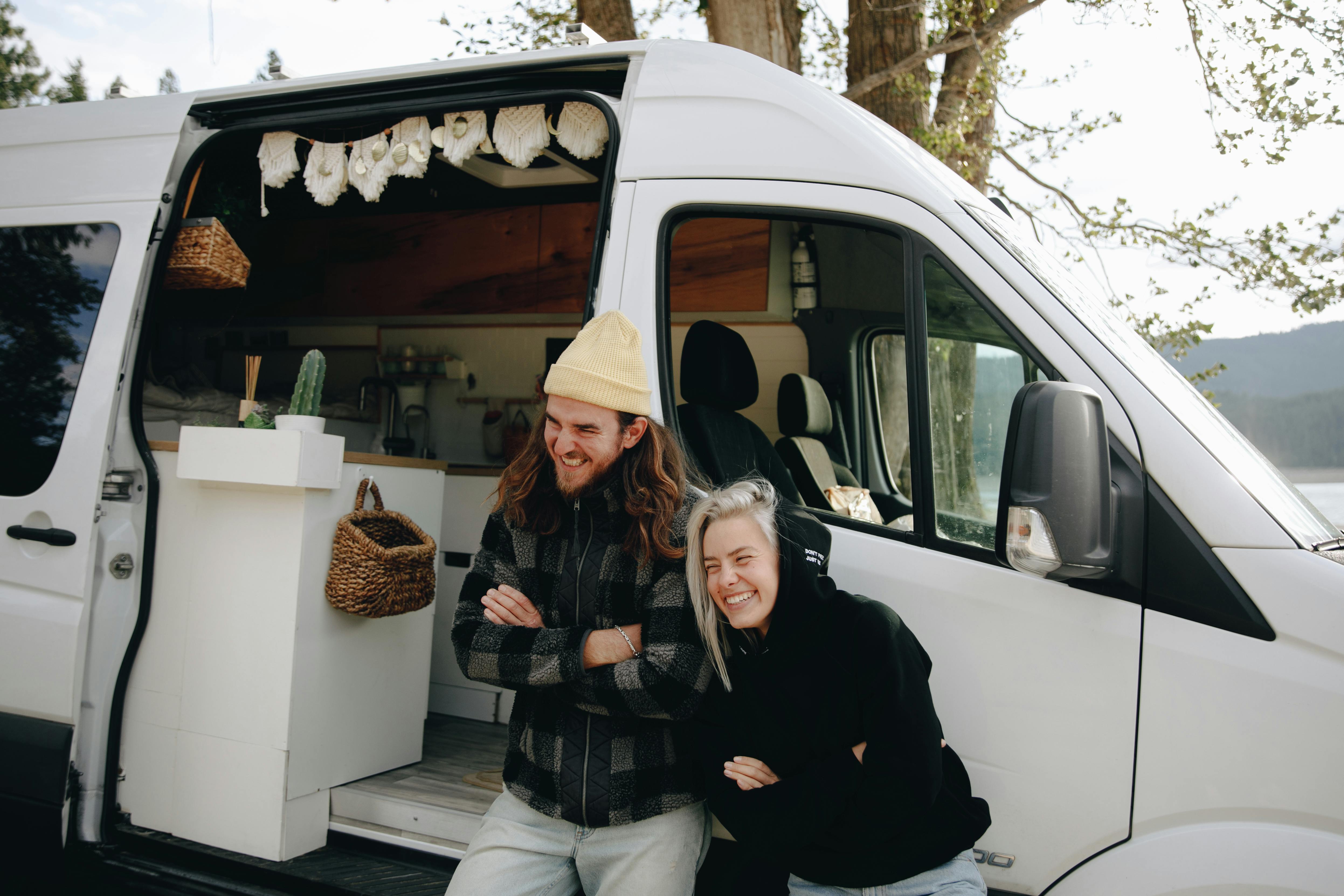 Couple Laughing Together While Sitting on White Van · Free Stock Photo