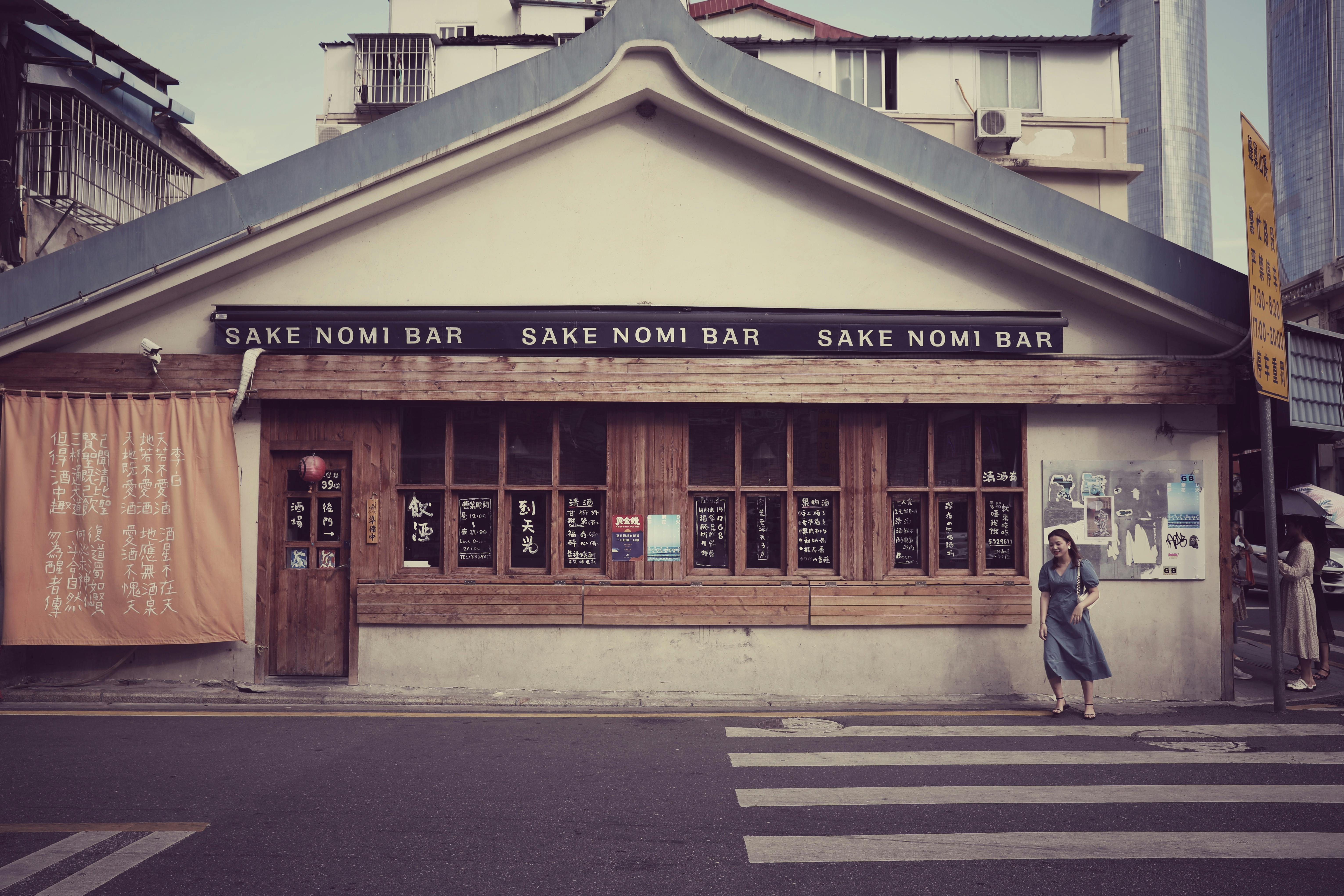 Bar Building and Woman Crossing Street · Free Stock Photo