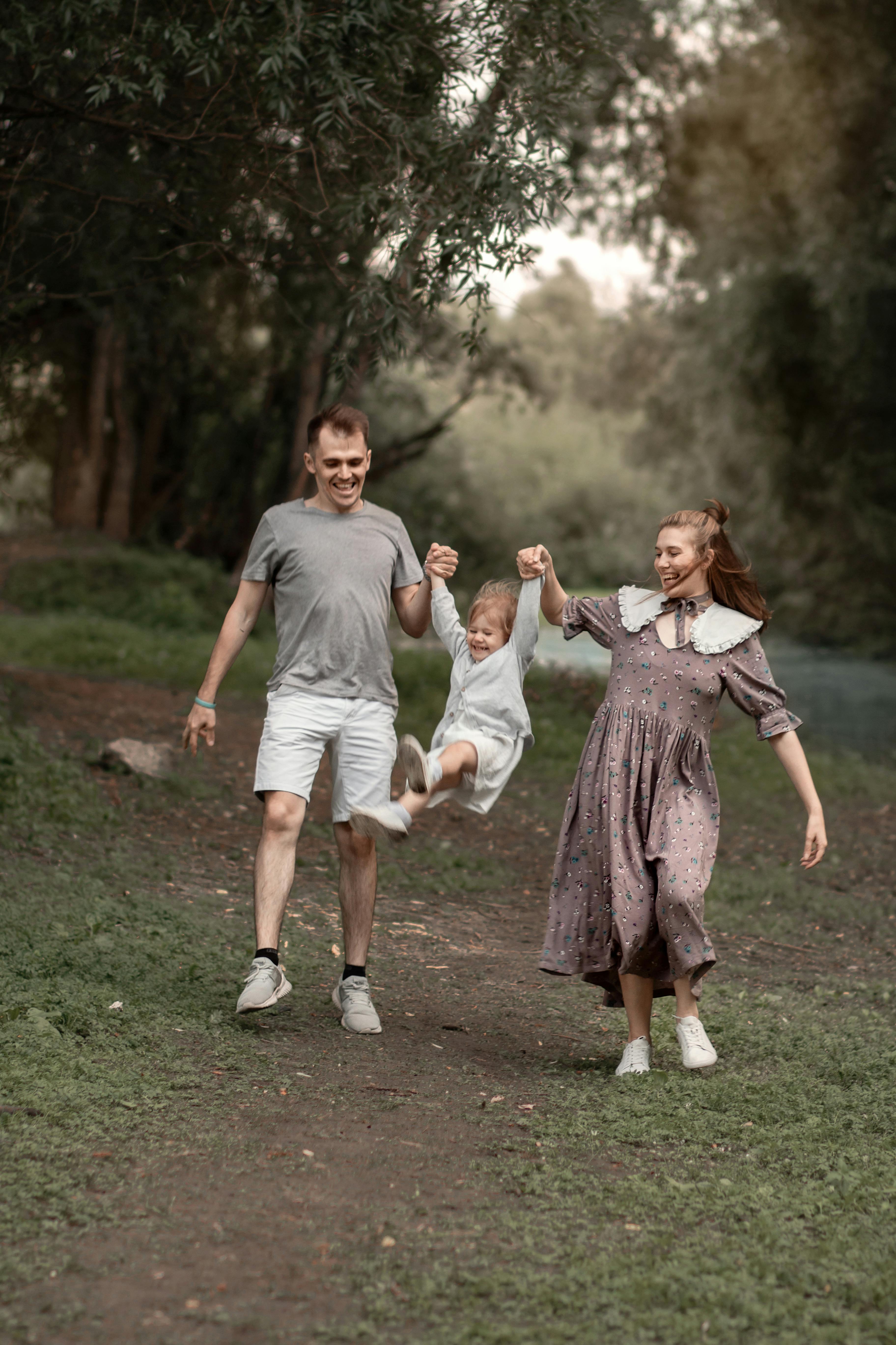 Parents Holding Their Daughter and Rising Her in the Air · Free Stock Photo