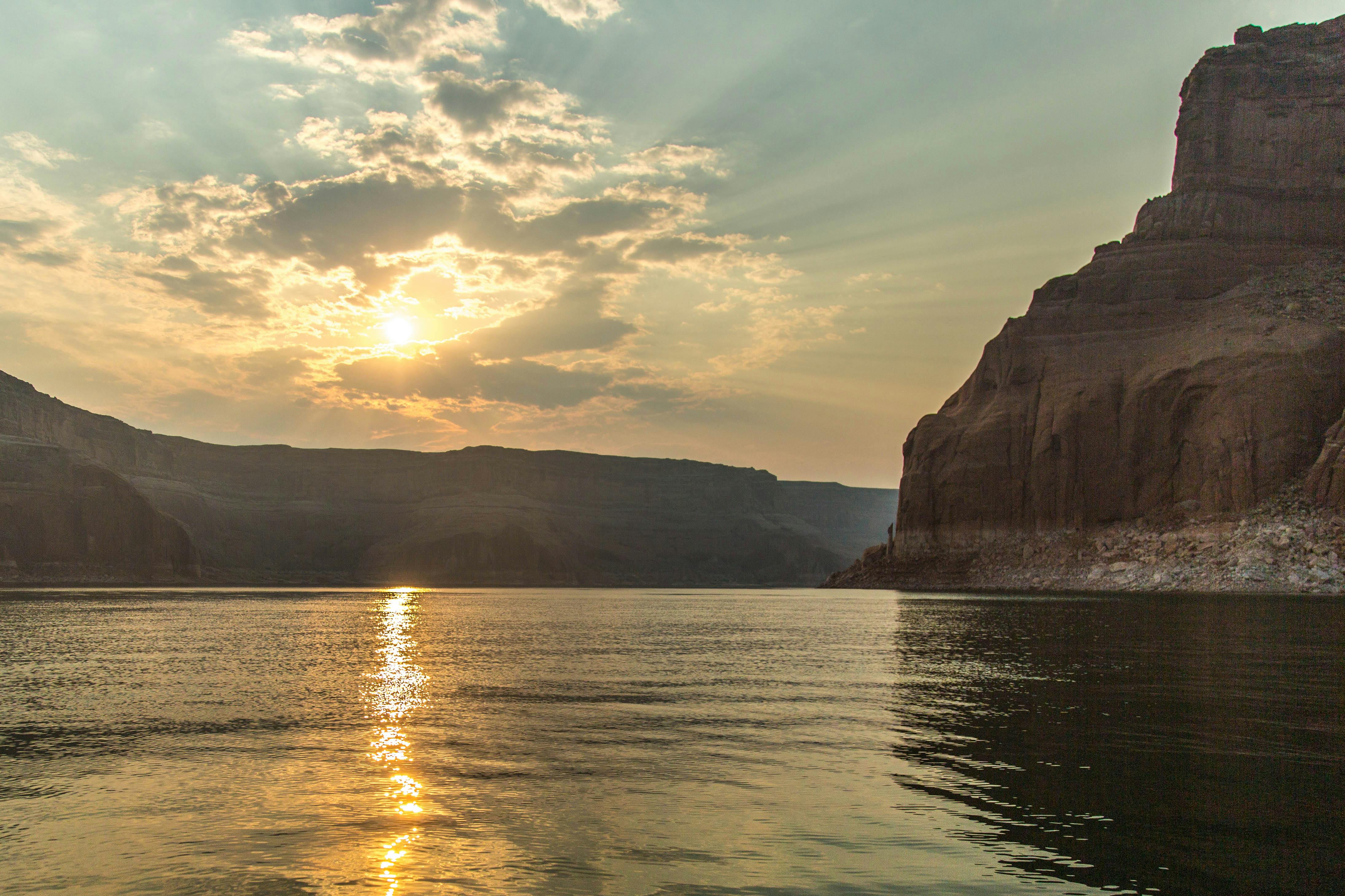 Brown Rock Formations Beside Body of Water · Free Stock Photo