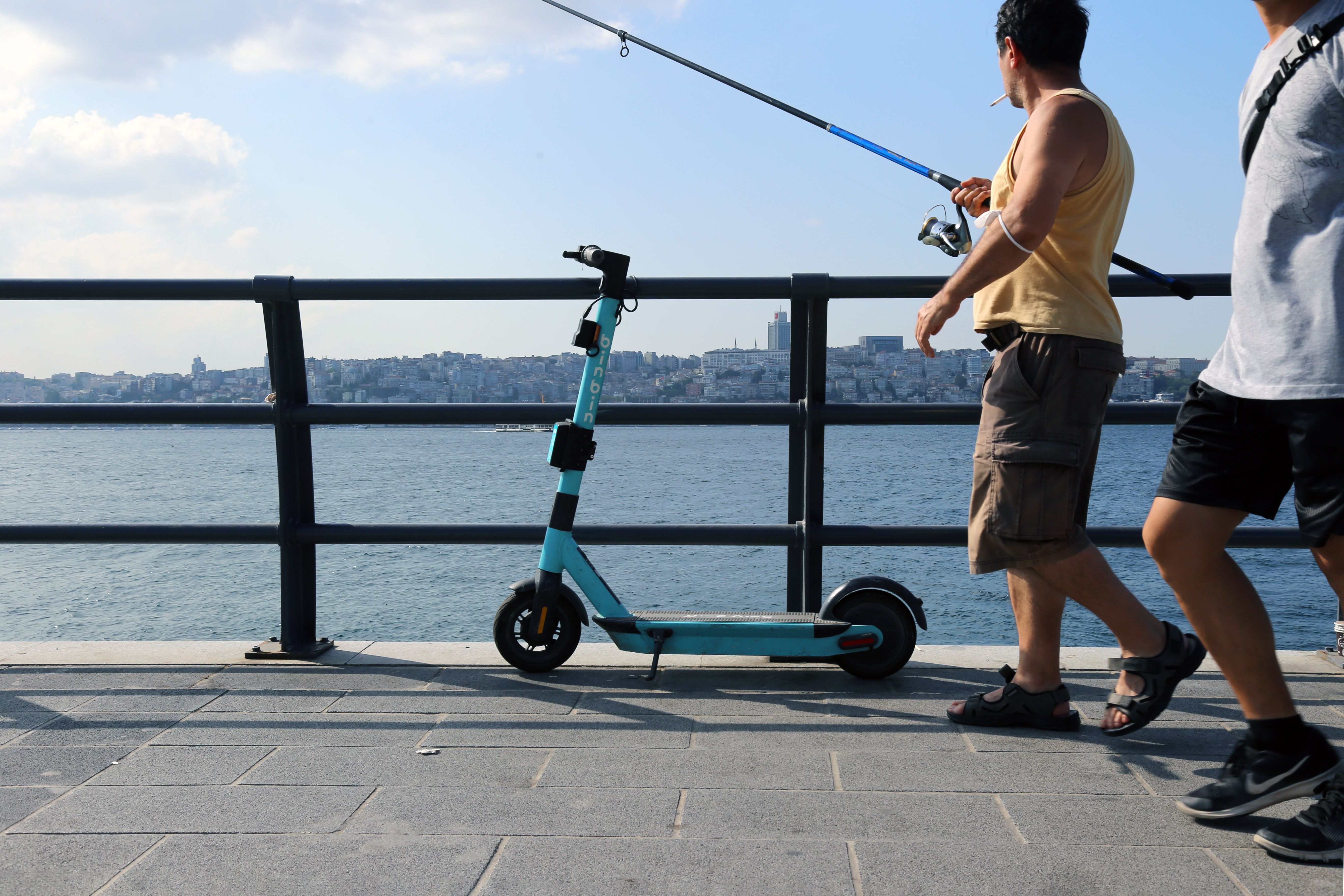 Scooter and a Man Fishing from a Bridge · Free Stock Photo