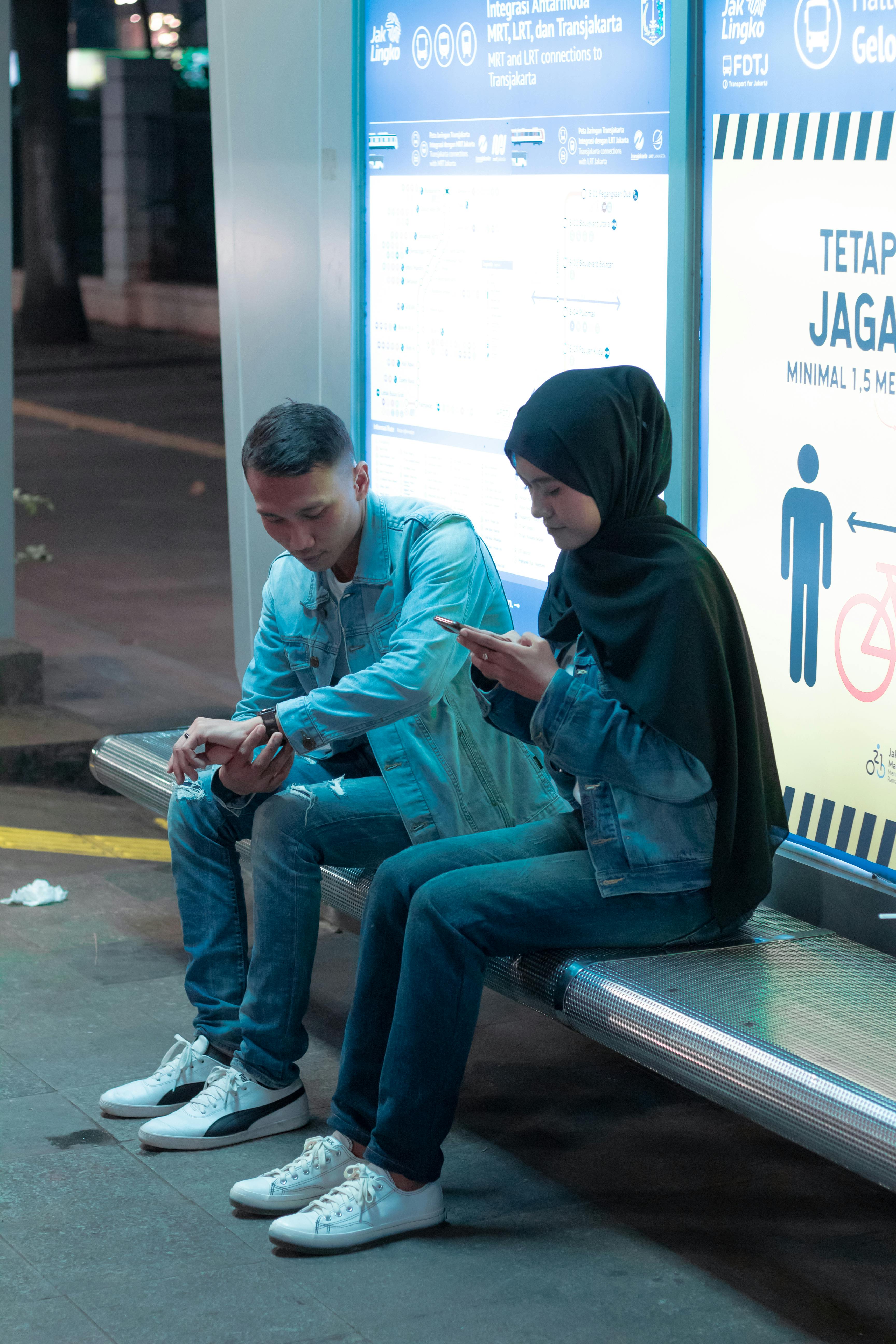 People Sitting on Bench at a Bus Stop · Free Stock Photo