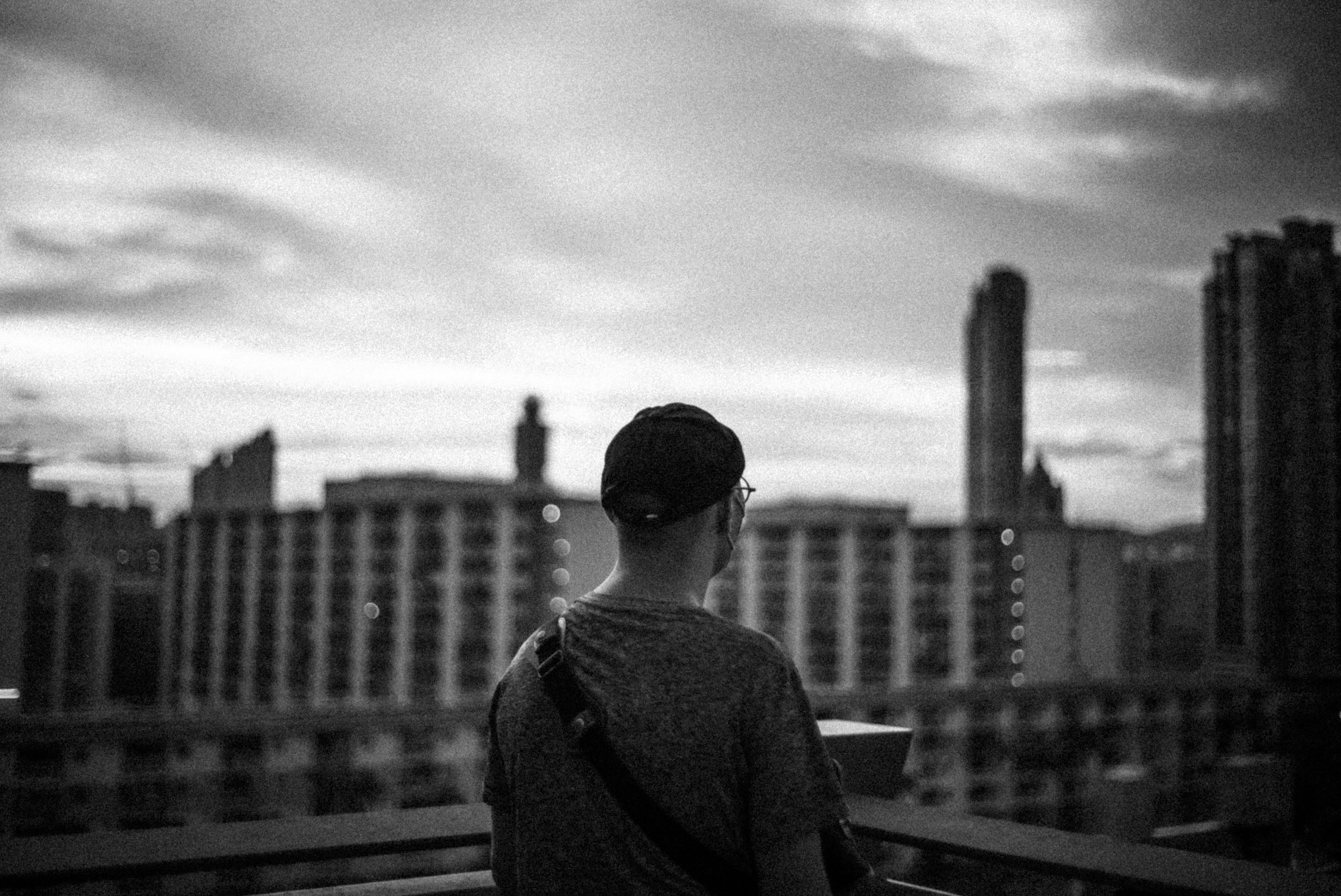 Man Standing Near Concrete Buildings · Free Stock Photo
