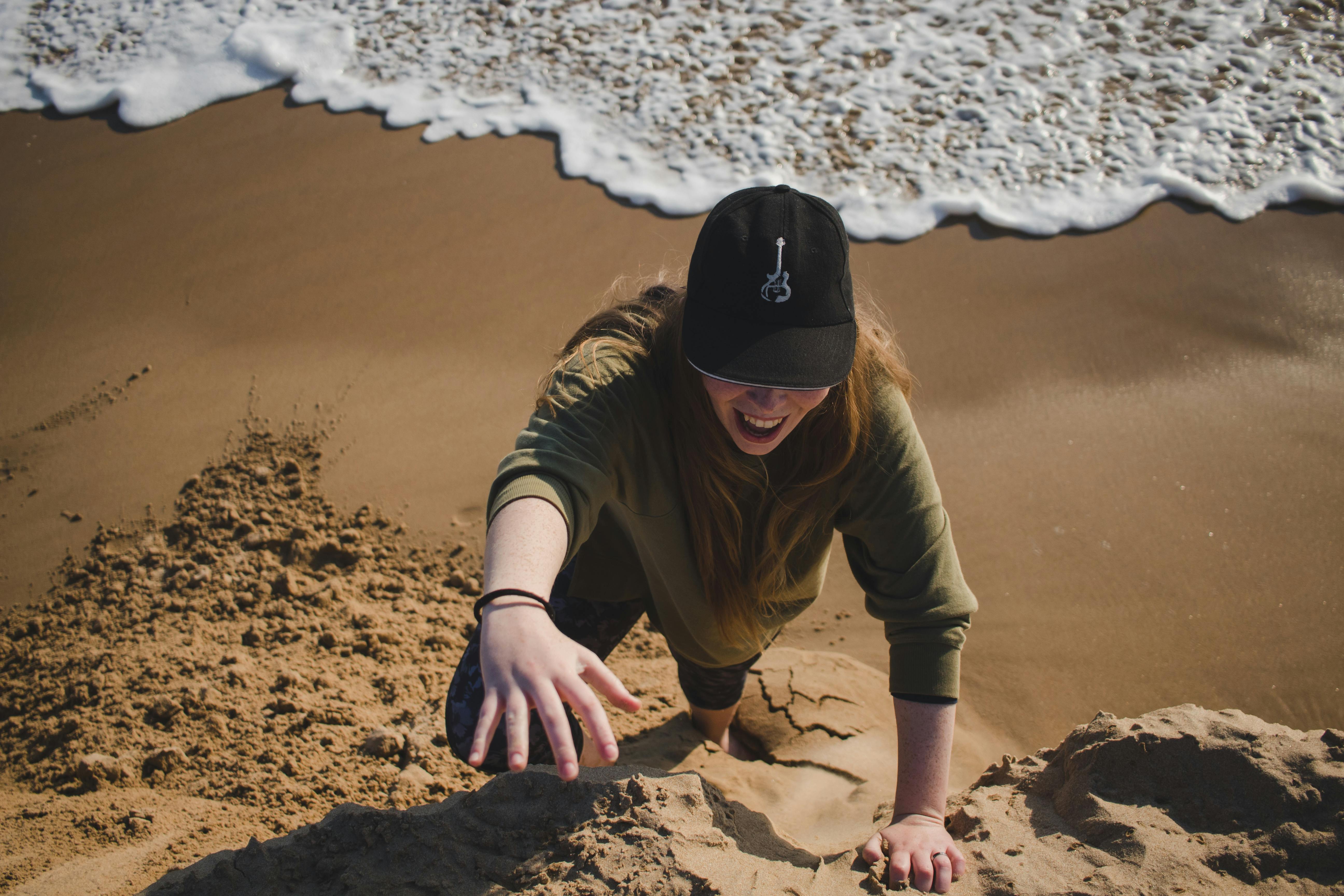 A Woman Climbing on the Sand · Free Stock Photo
