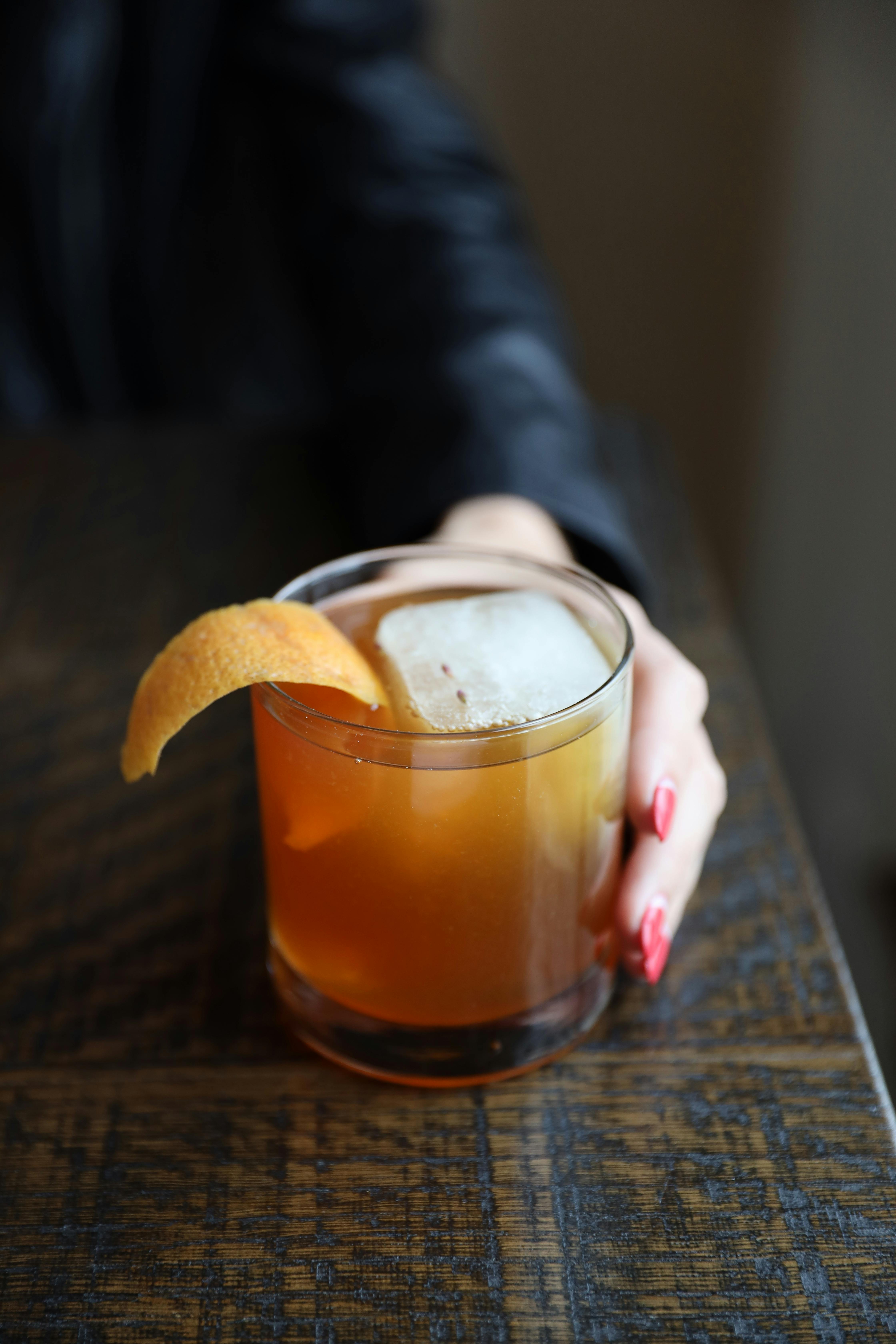 A Person Holding a Glass of Dring with Ice and Orange Peel · Free Stock ...