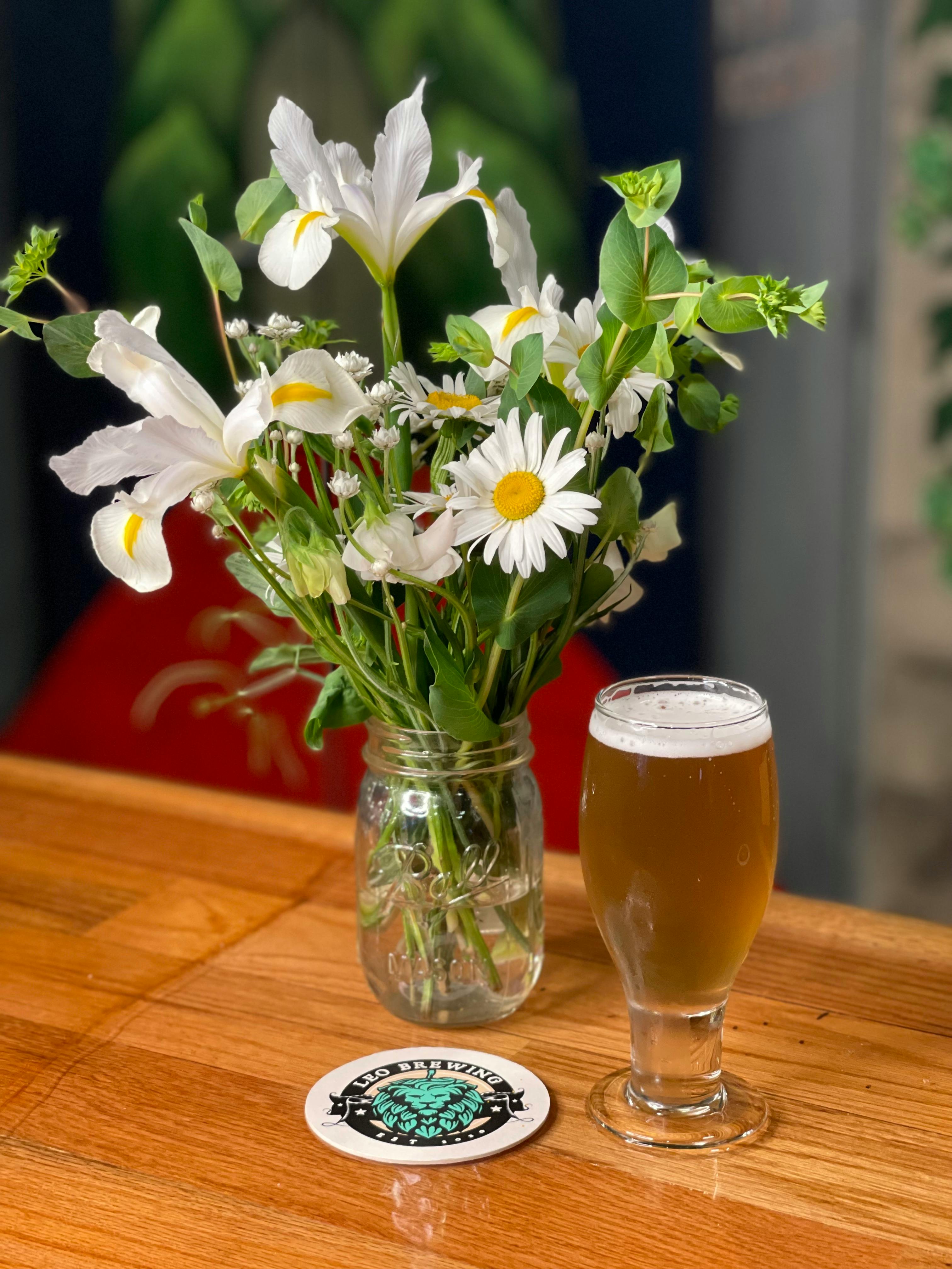 White Flowers Beside a Glass of Beer · Free Stock Photo