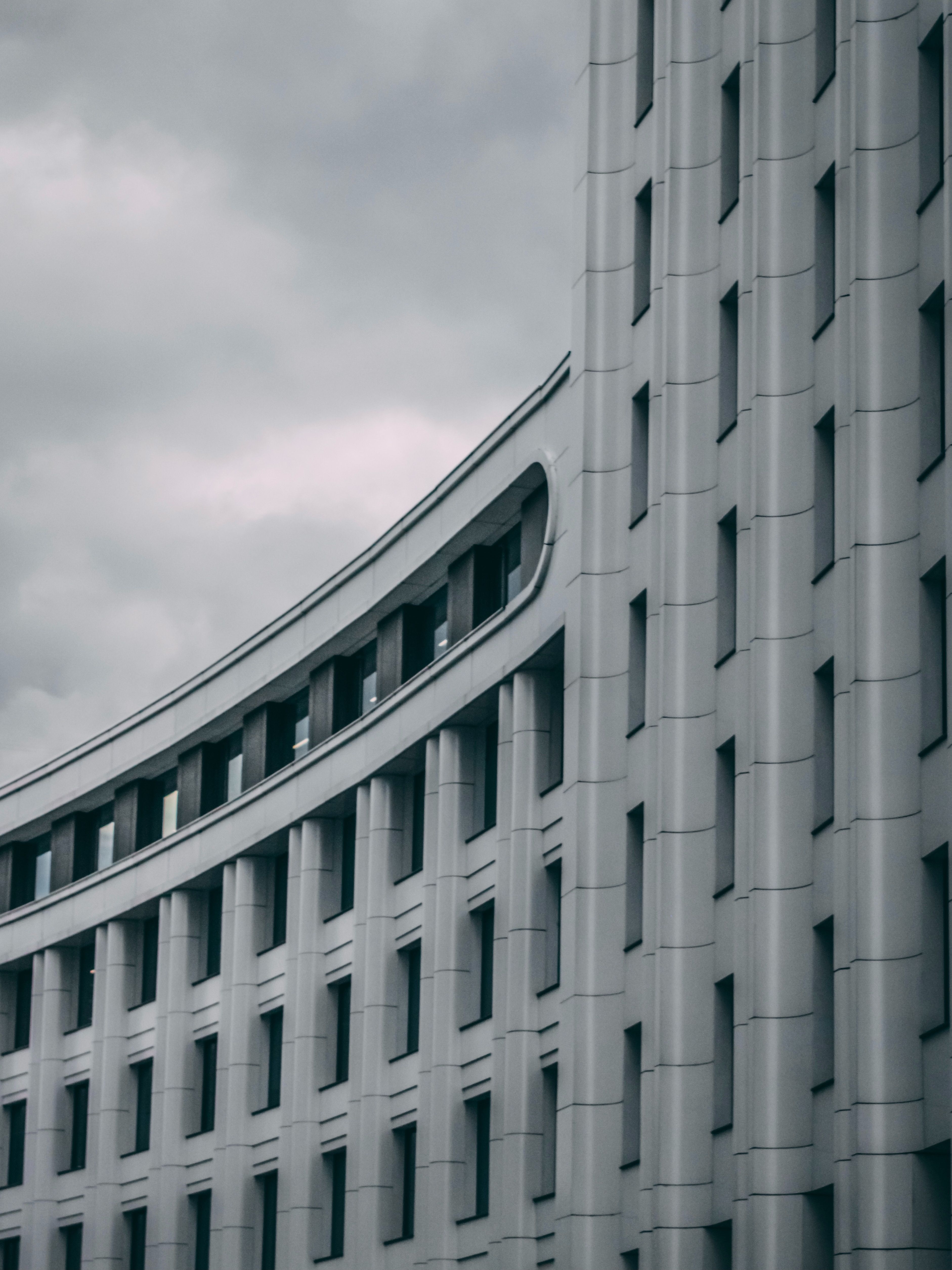 White Concrete Building Under White Clouds · Free Stock Photo