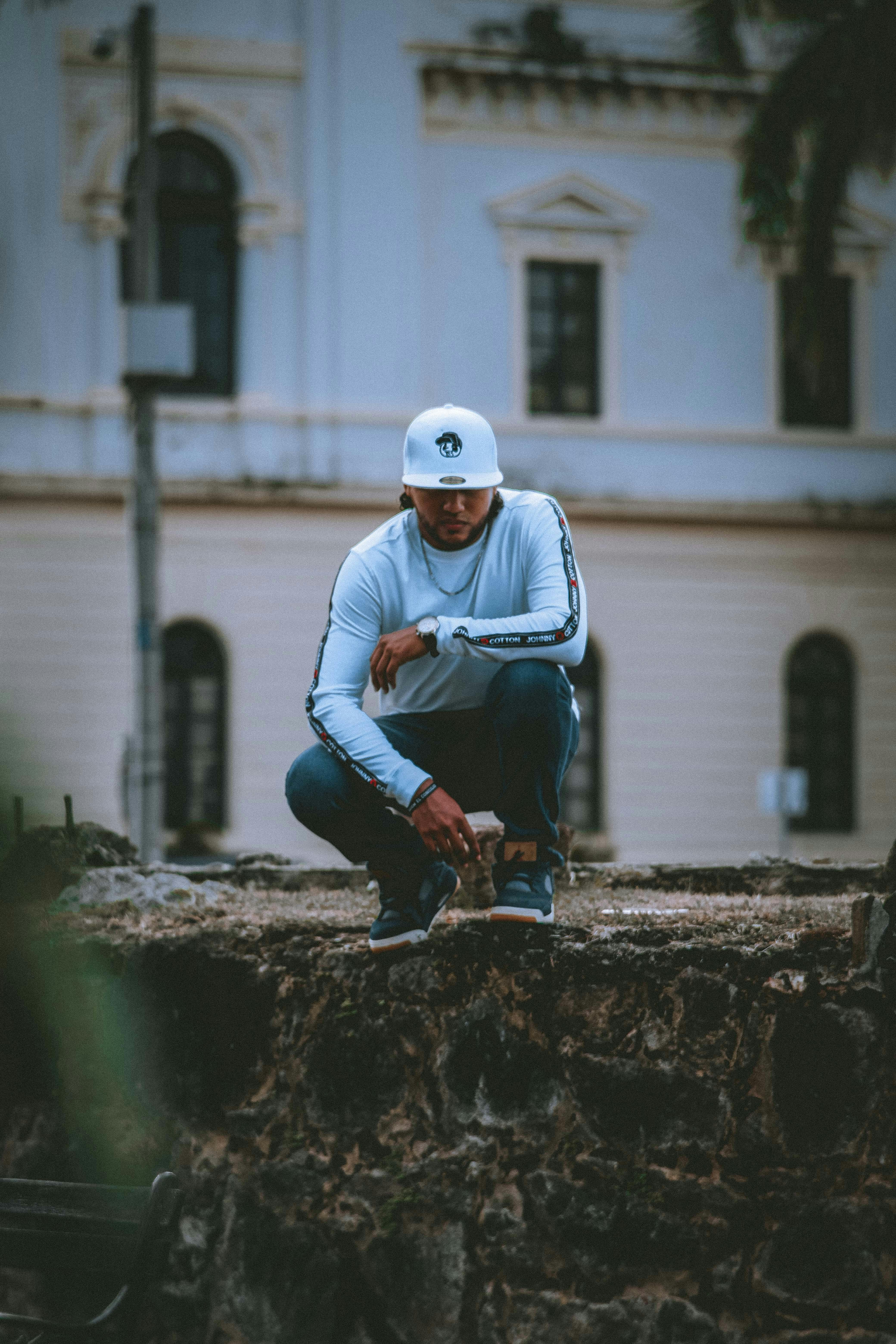 Man Crouching on Ledge · Free Stock Photo