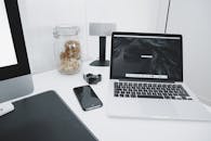 Laptop & cell phone on a wooden desk · Free Stock Photo