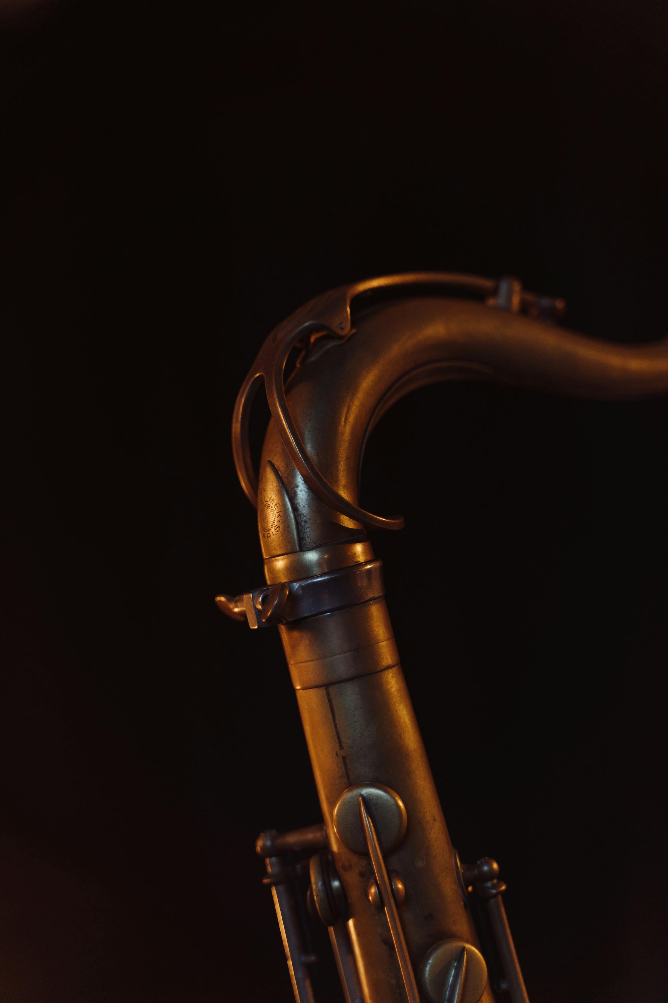 Brass Saxophone on Gray Table Near Black Bag · Free Stock Photo