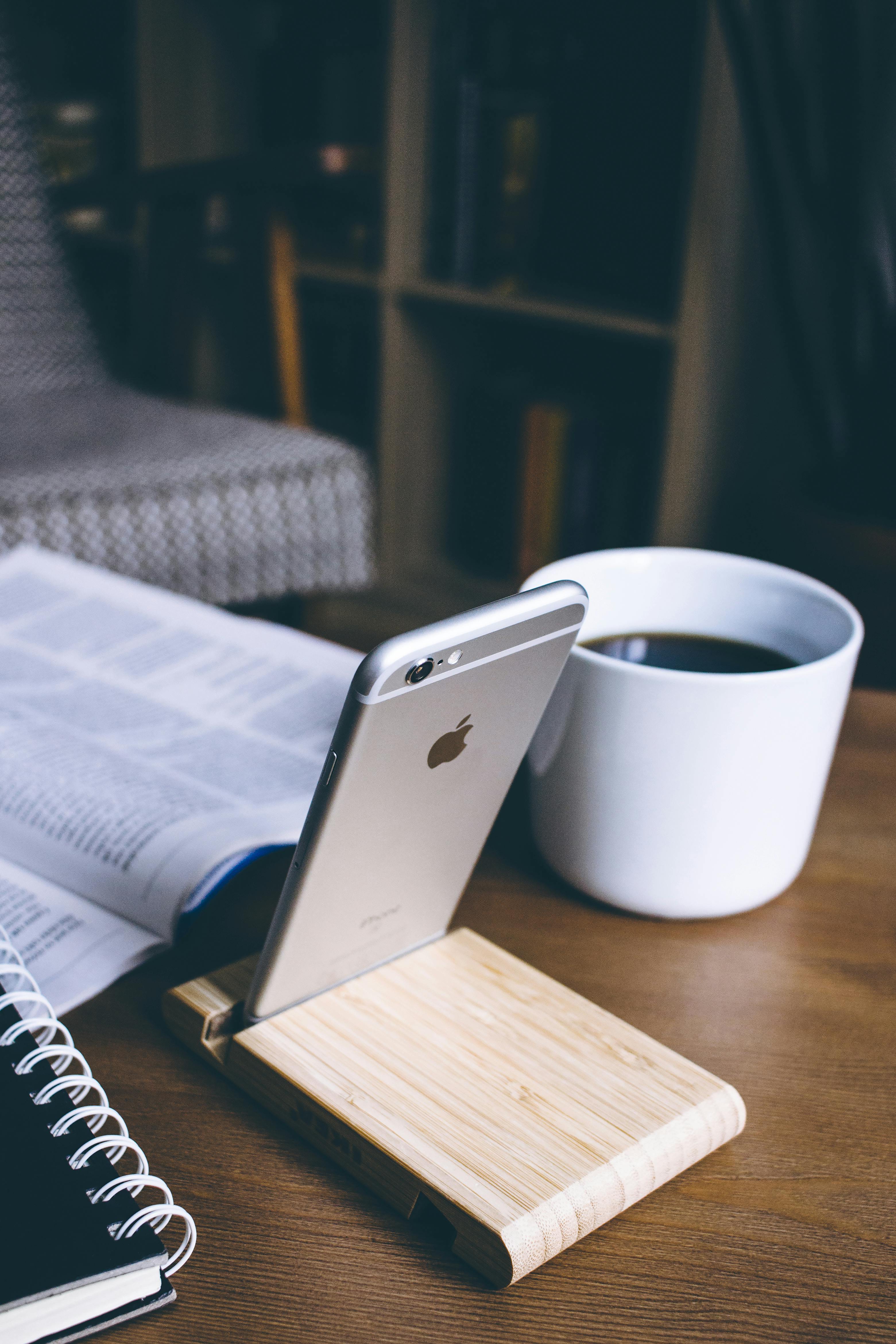 Silver Iphone on Brown Wooden Rack on Top of Table · Free Stock Photo