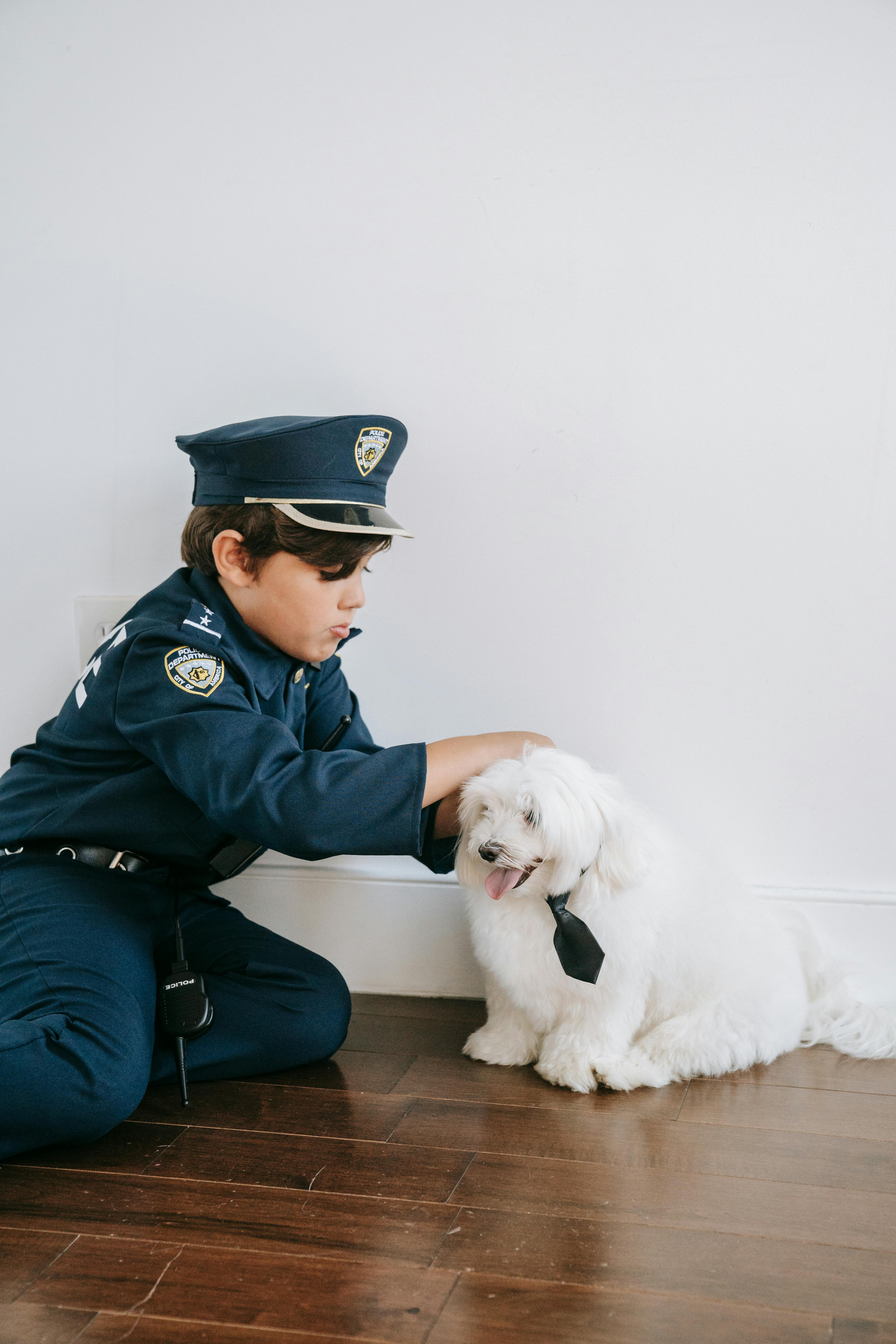 A Boy in a Police Costume Playing with His Dog · Free Stock Photo