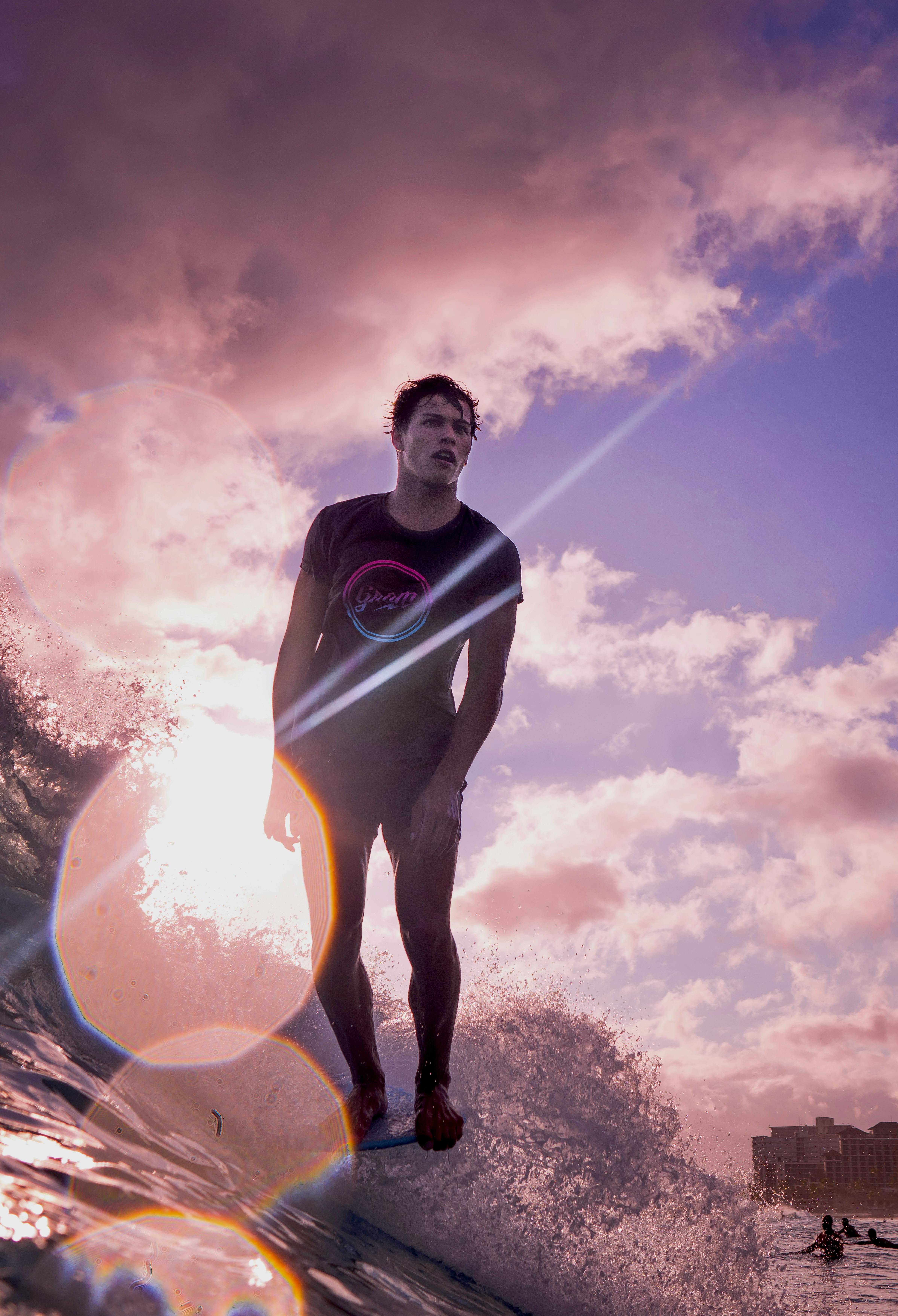 Man standing in the edge of Surfboard · Free Stock Photo