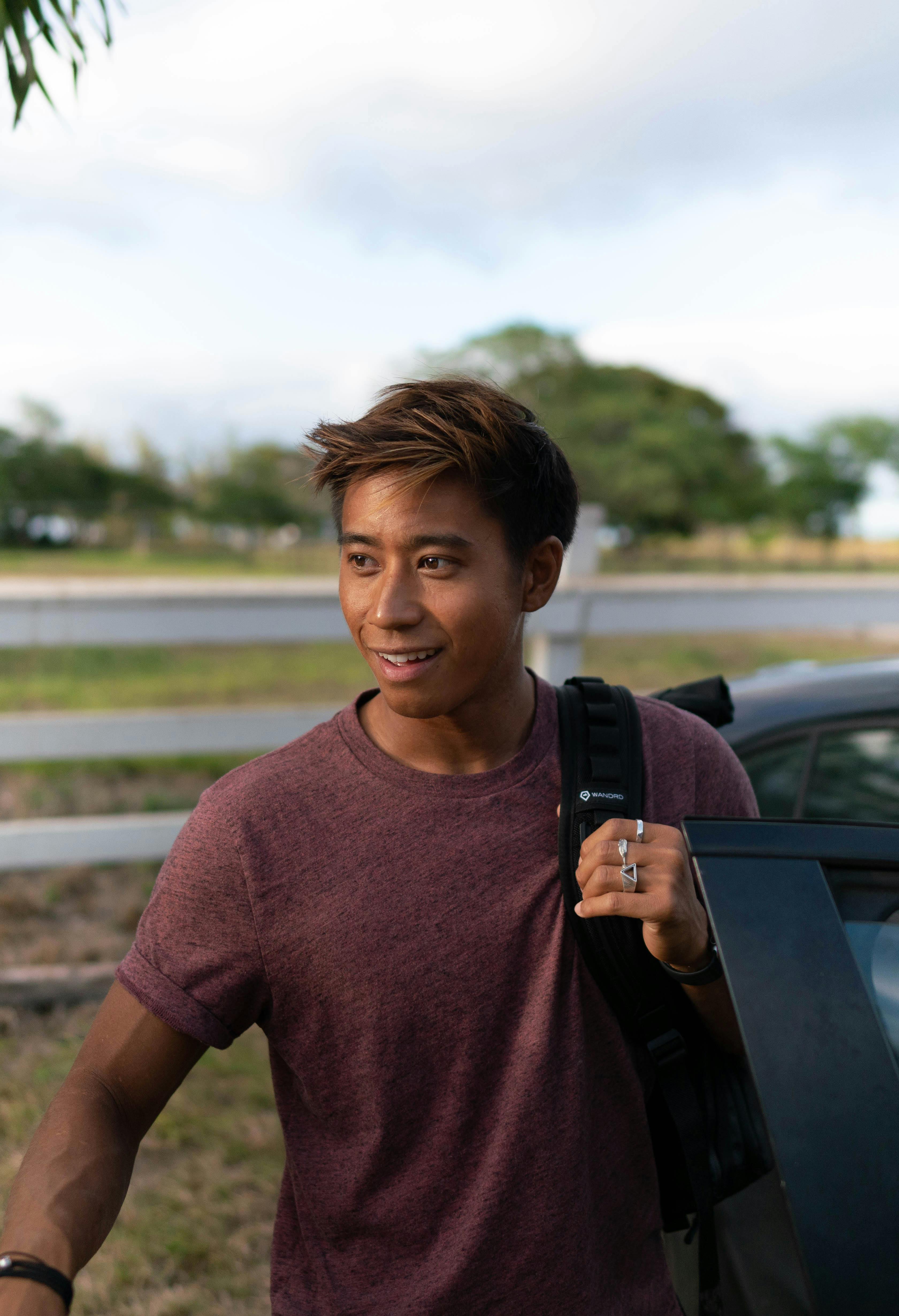 Man in Maroon Crew Neck T-shirt Standing Beside Car · Free Stock Photo