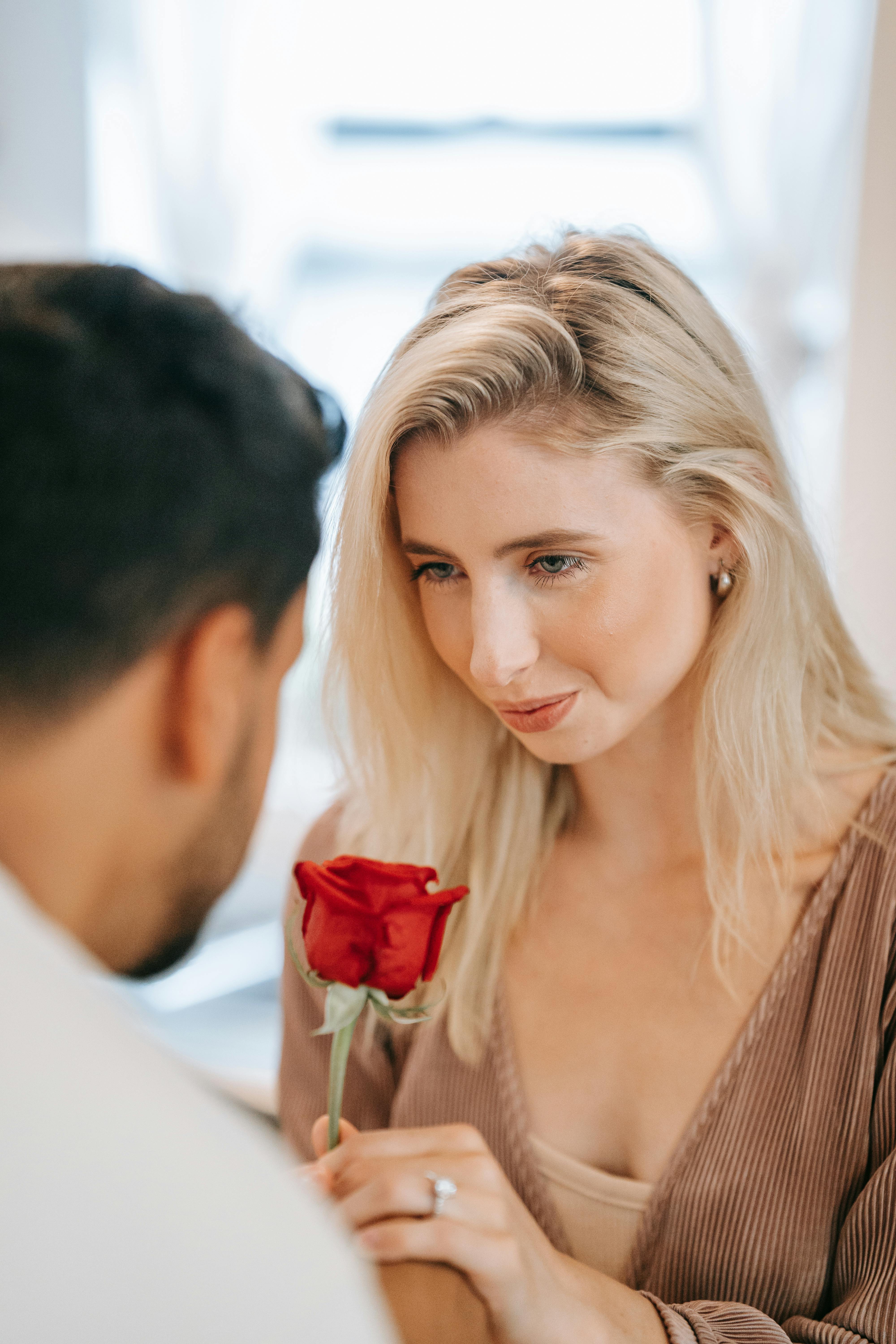 A Woman Holding a Red Rose · Free Stock Photo