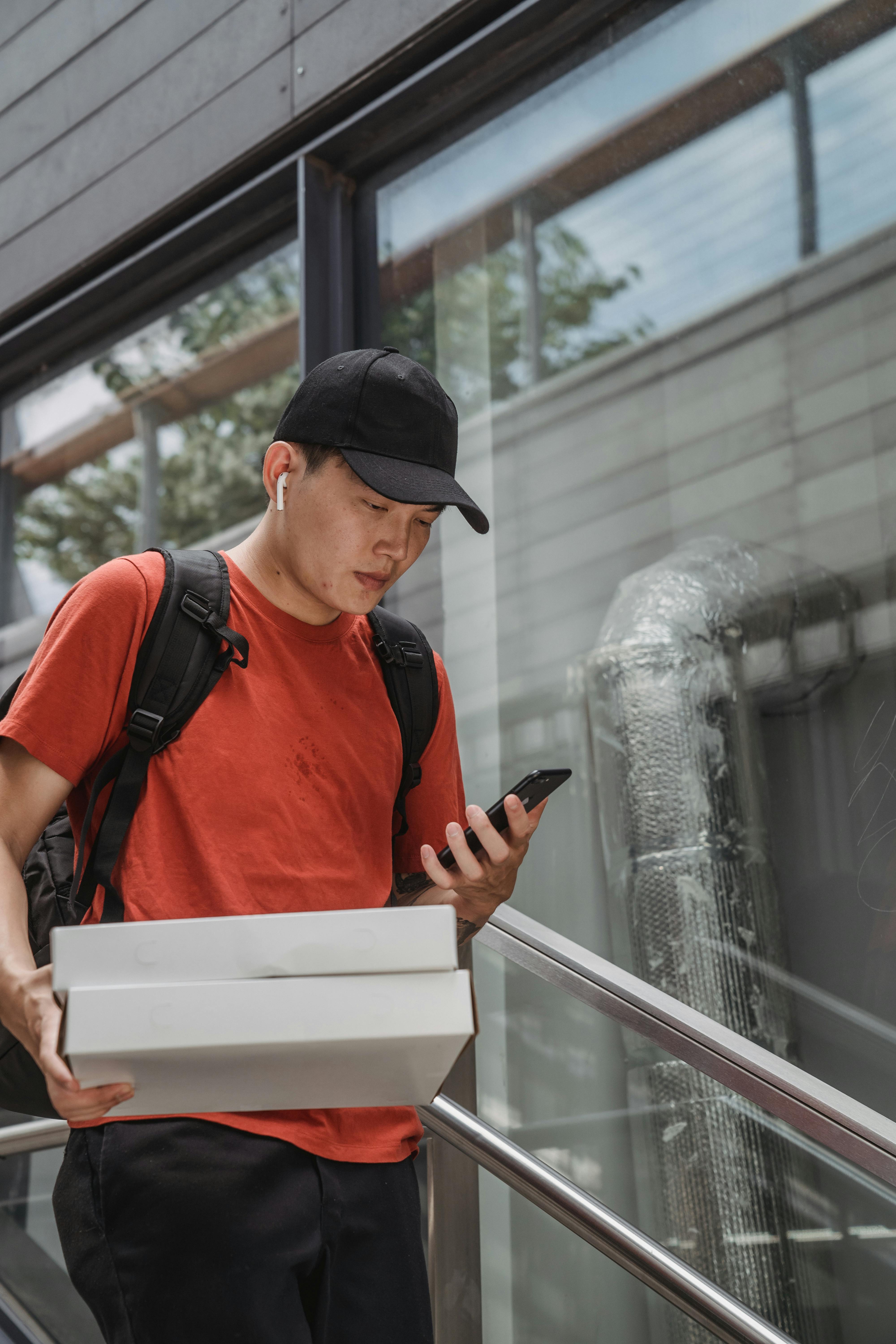 Photo of a Man with a Black Cap Looking at His Cell Phone · Free Stock ...