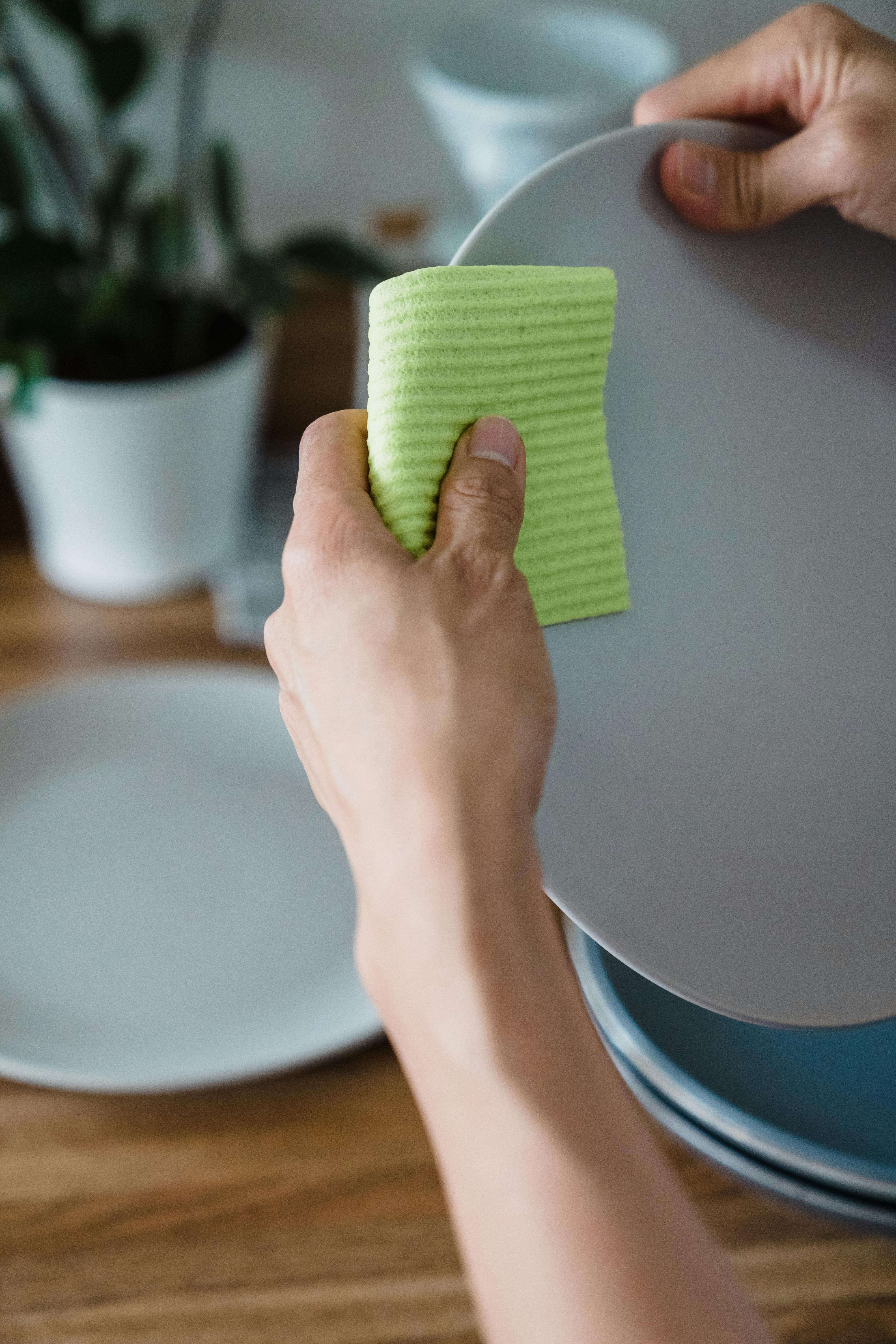 A Person Wiping a Plate with a Cloth · Free Stock Photo