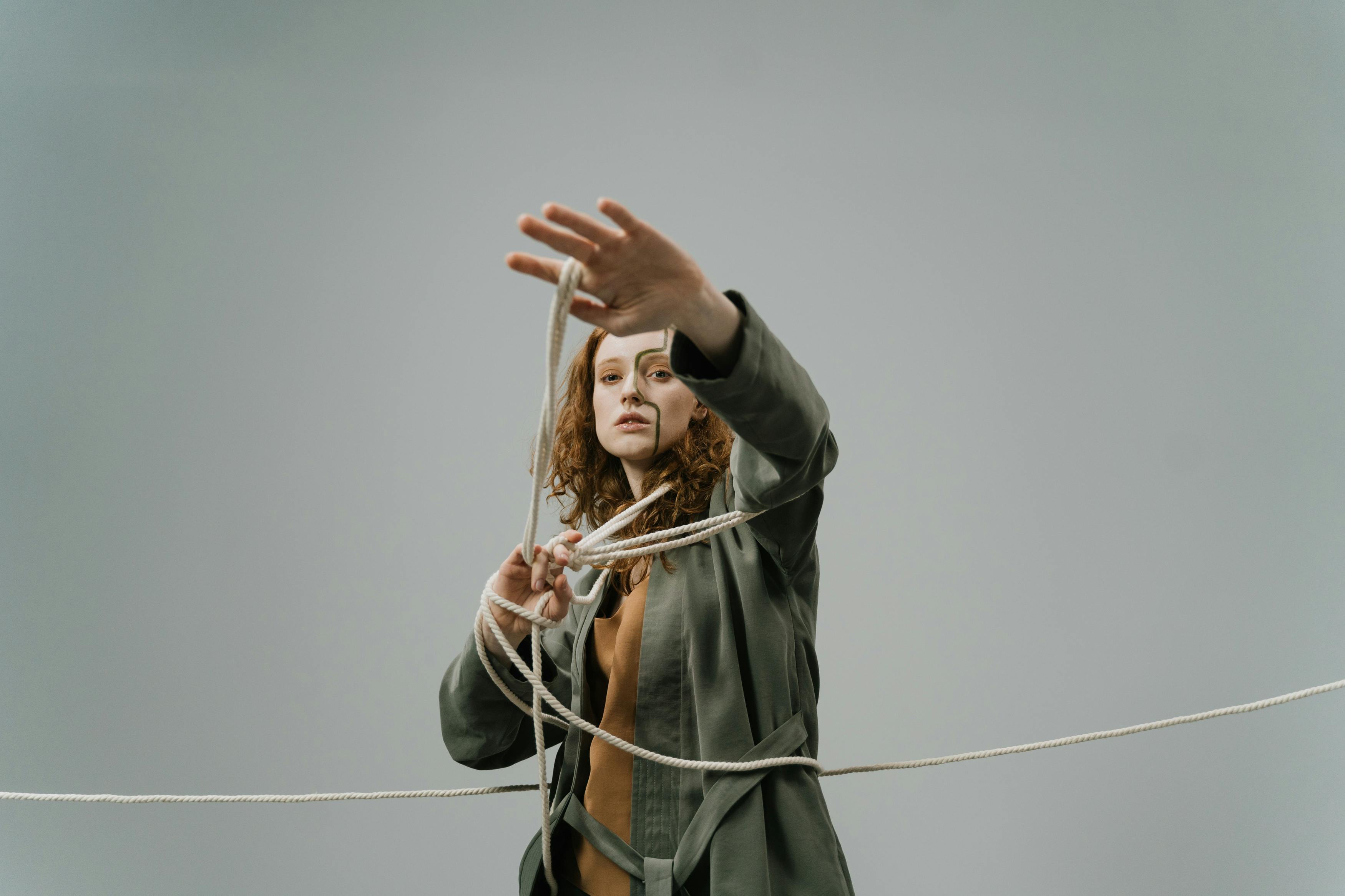 A Woman in Gray Robe Holding White Rope · Free Stock Photo