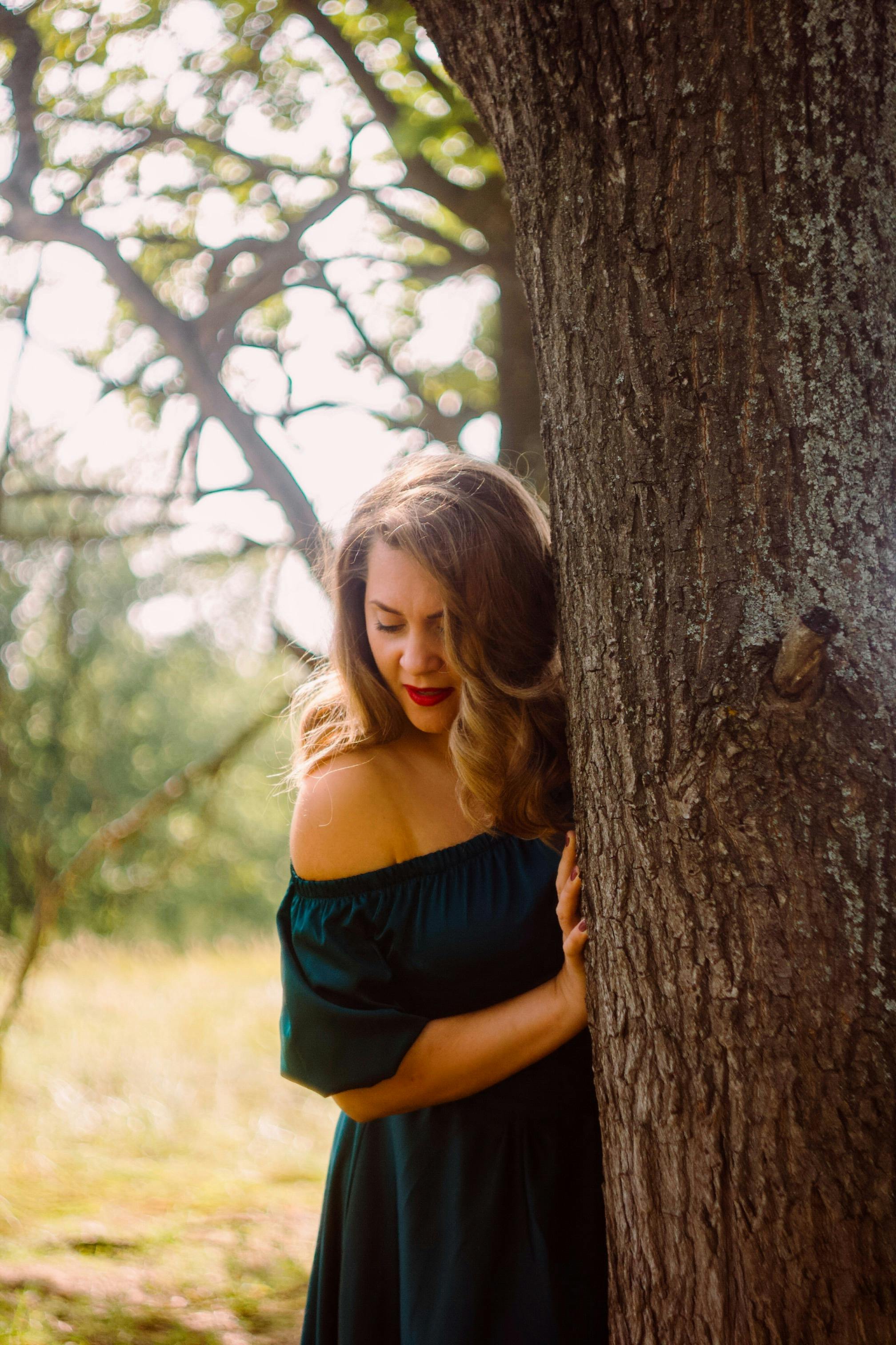 Woman in a Blue Dress Standing behind a Tree · Free Stock Photo