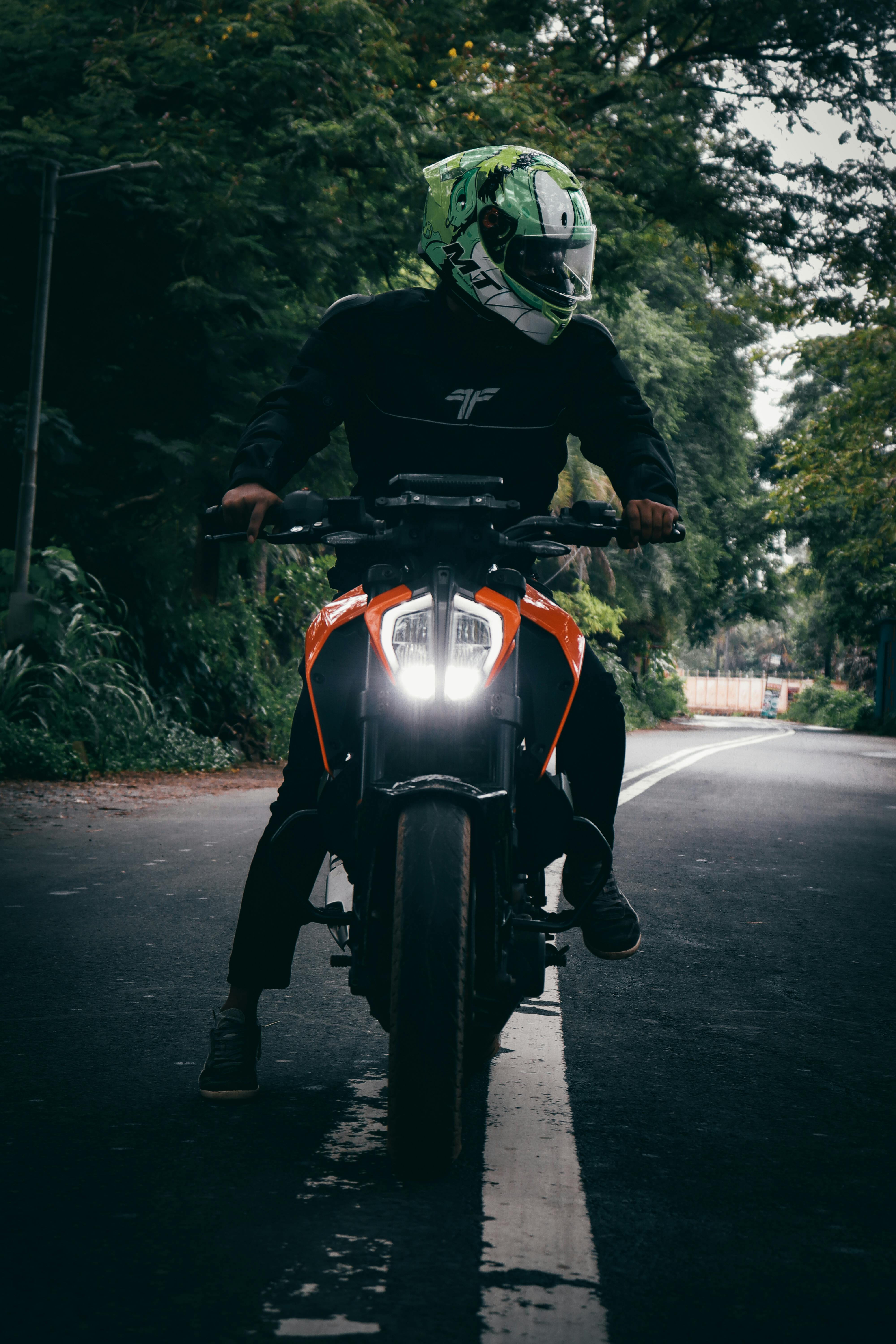 Person in Orange Jacket Riding Red Motor Scooter · Free Stock Photo