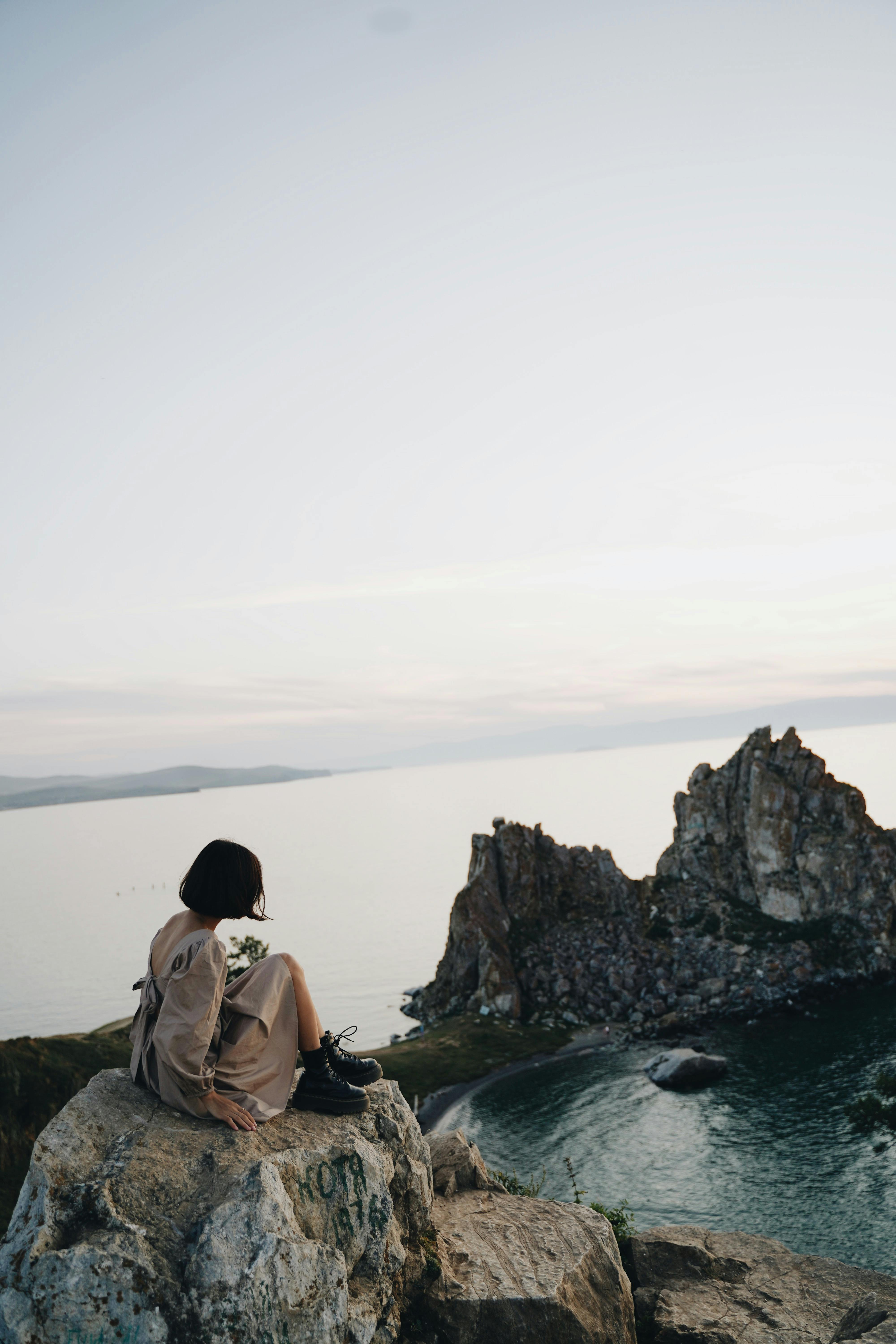 Woman in Beige Dress Hopping on Rocks · Free Stock Photo