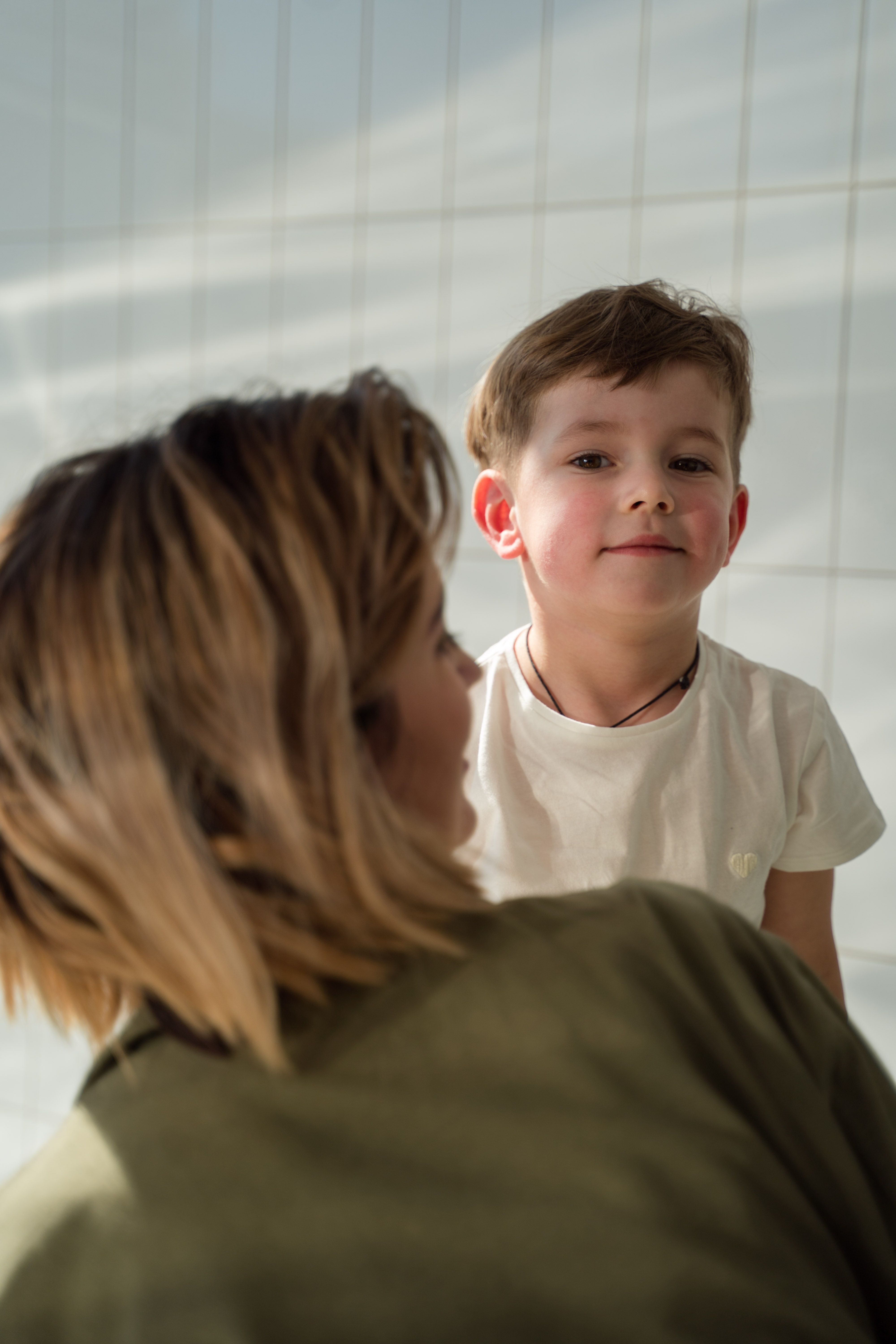 A Boy Looking over his Mother's Shoulder · Free Stock Photo