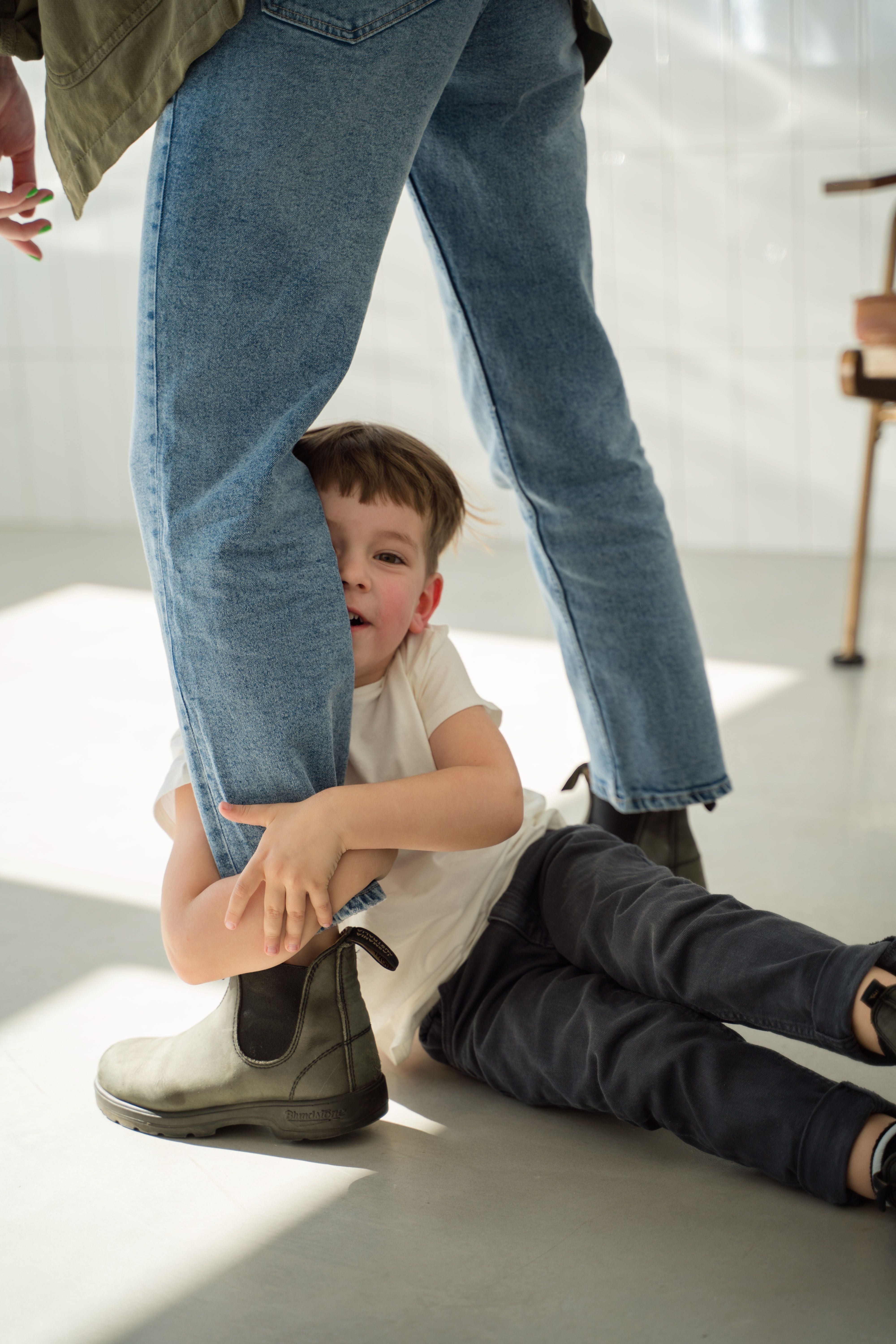 Boy Sitting on the Floor while Hugging a Person's Leg · Free Stock Photo