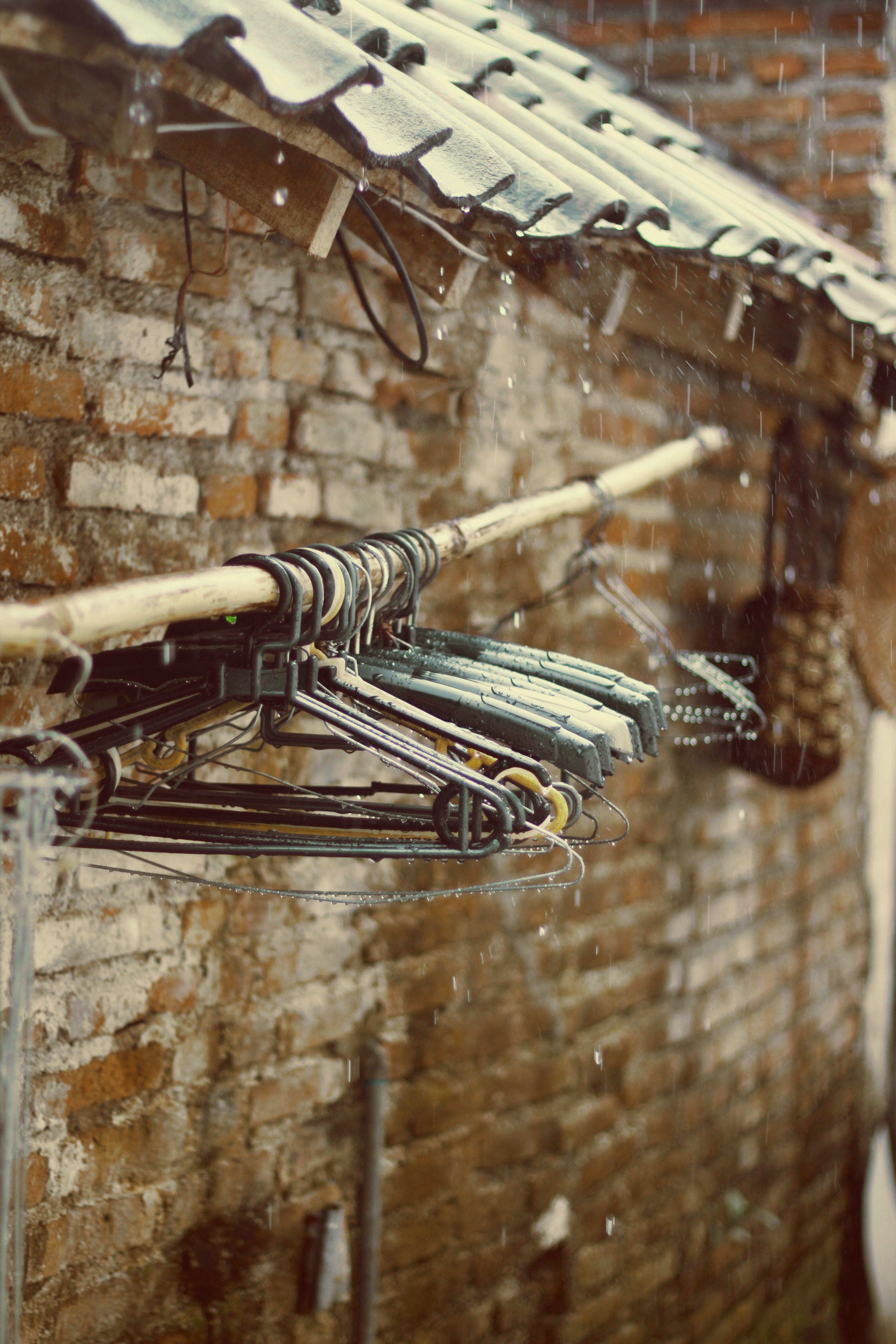 A Collection of Hangers Hanging on a Wooden Pole Under a Roof · Free ...