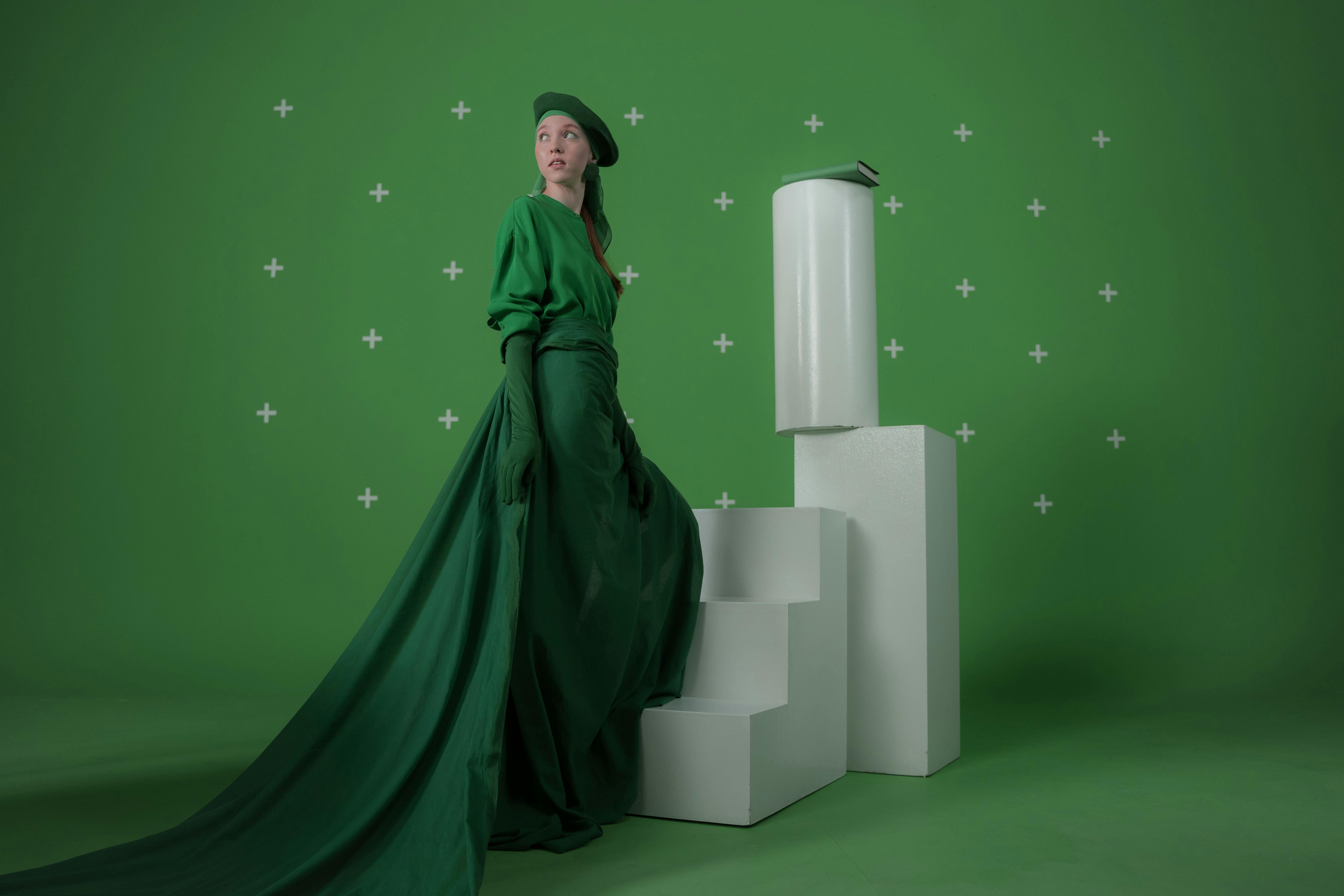 Young Woman in a Green Costume Posing in Studio on Green Background ...