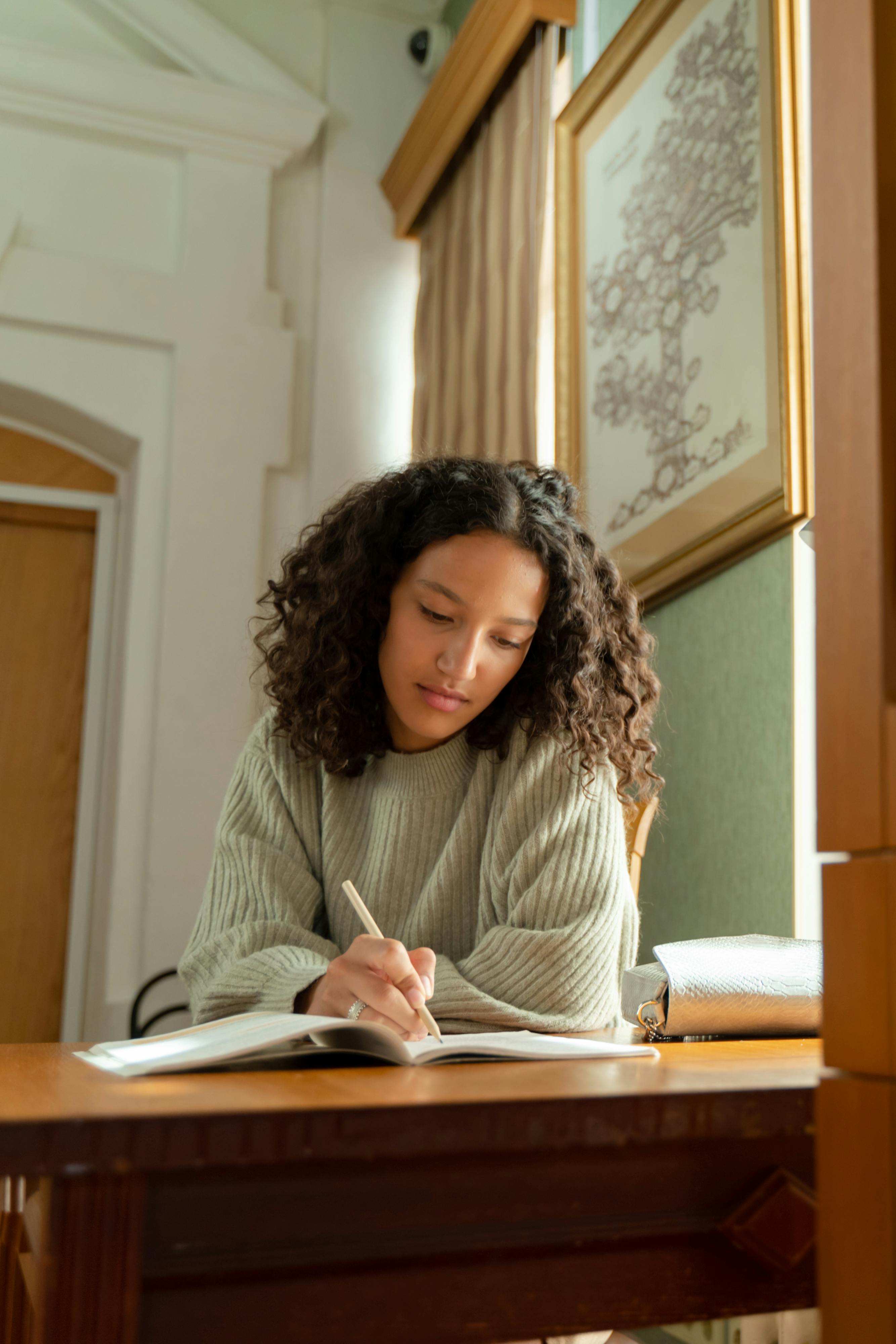 Woman in Green Sweater Writing · Free Stock Photo