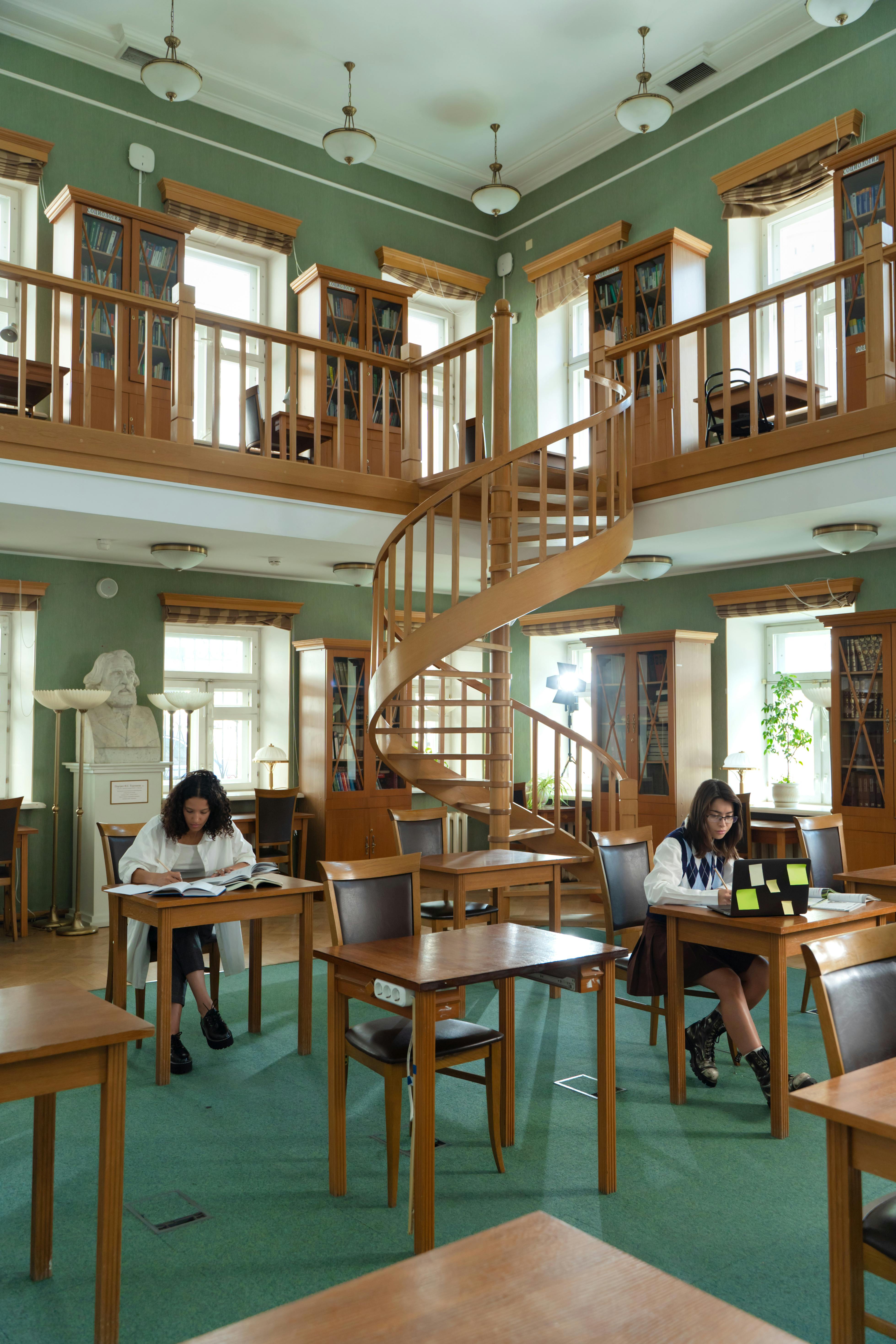 Women Sitting on Chair Inside a Library · Free Stock Photo