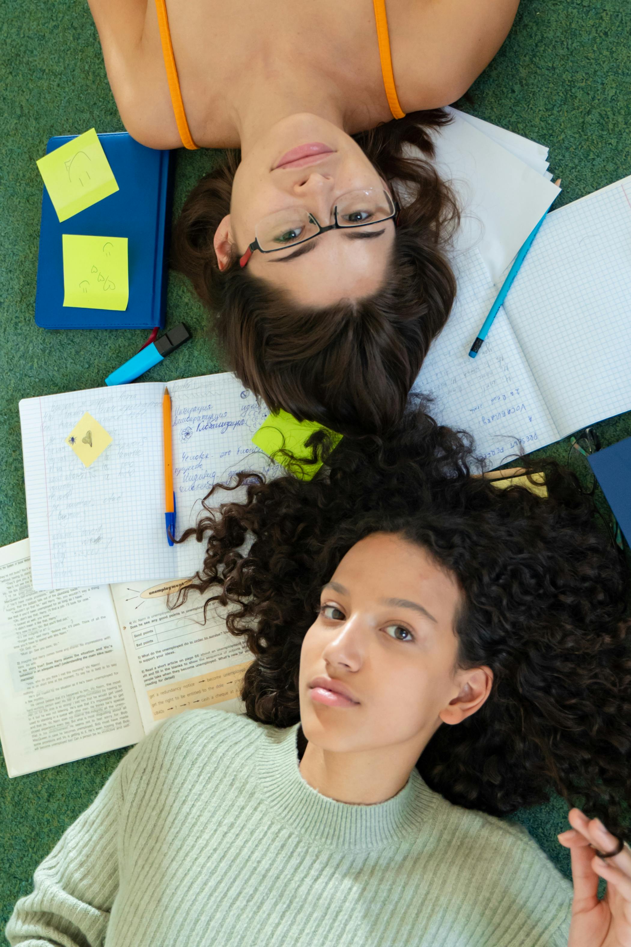 Women Lying on Books and Notebooks · Free Stock Photo