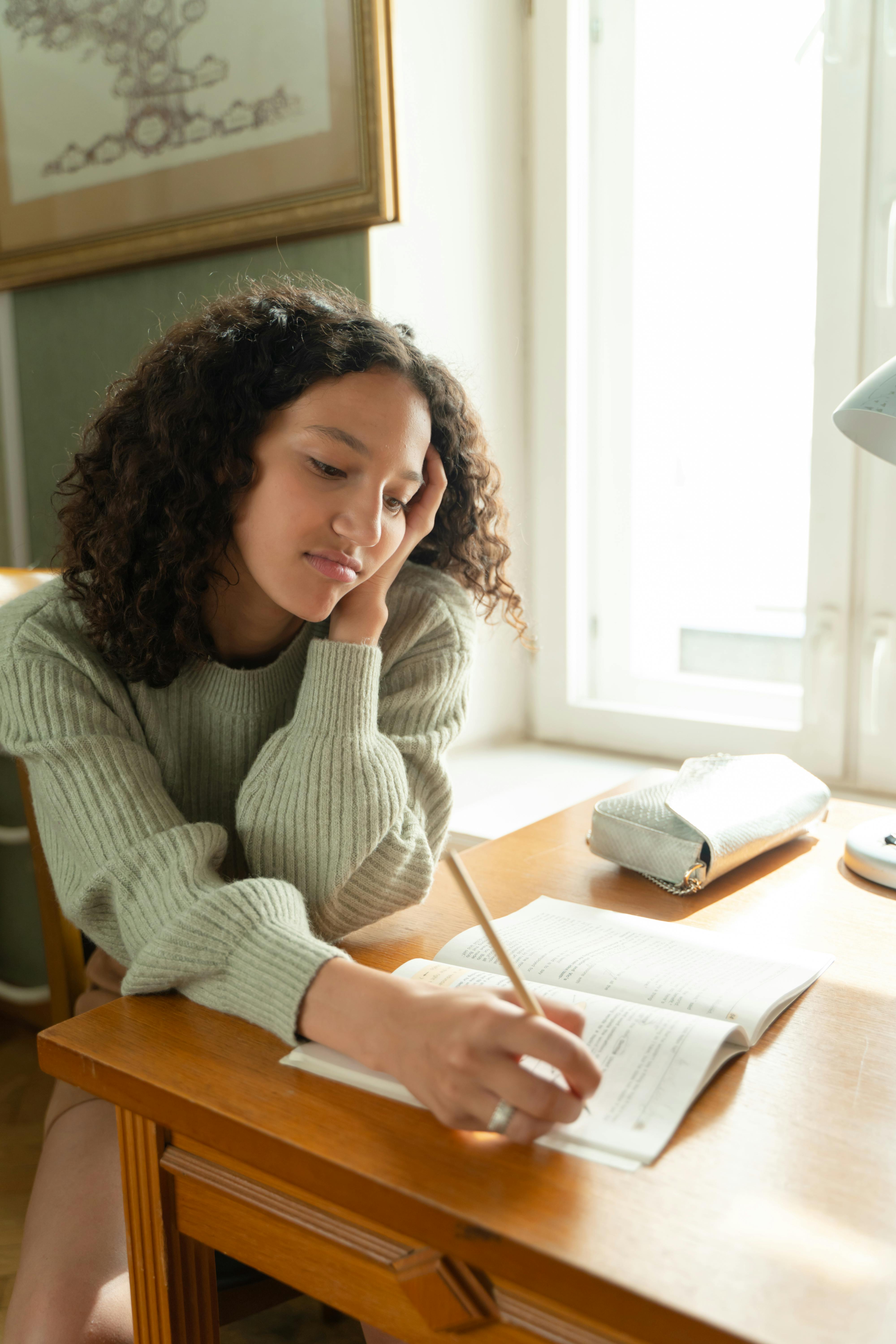 A Bored Student Reading a Textbook while Holding a Pencil · Free Stock ...