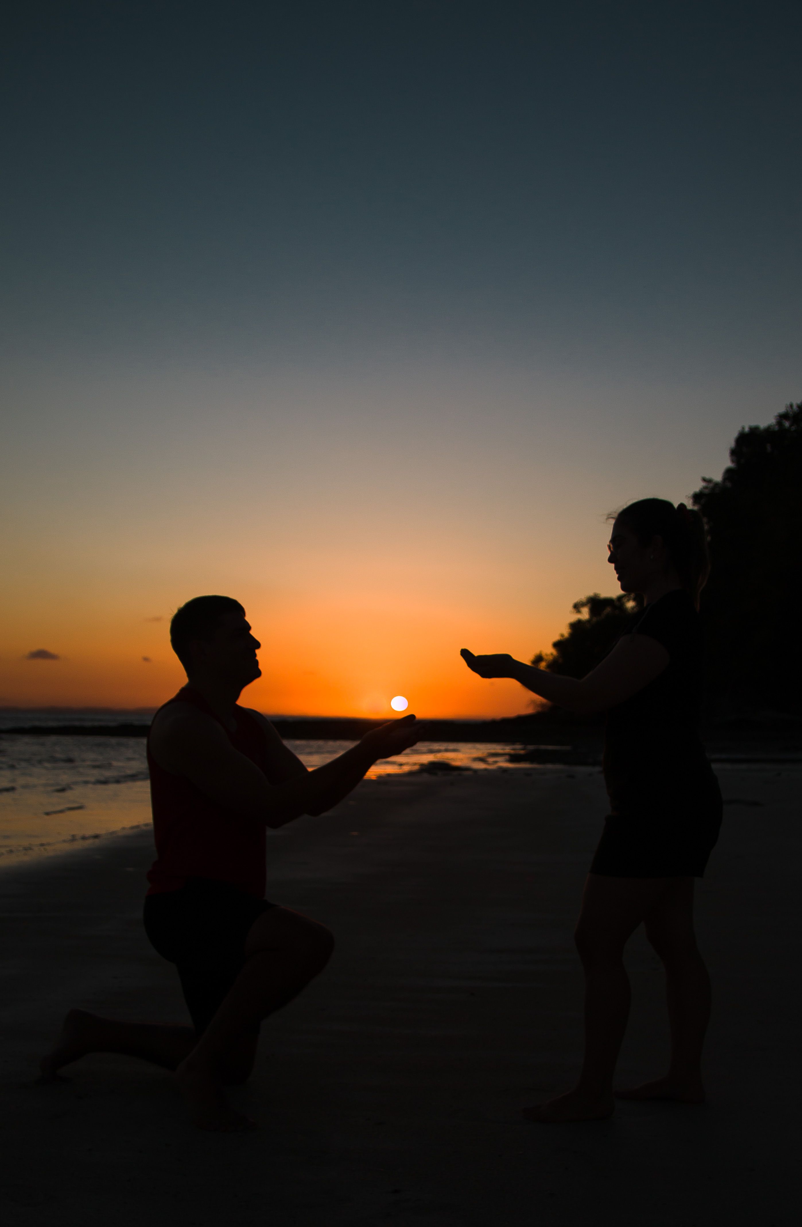 Man Giving Sun to Woman at Sunset · Free Stock Photo