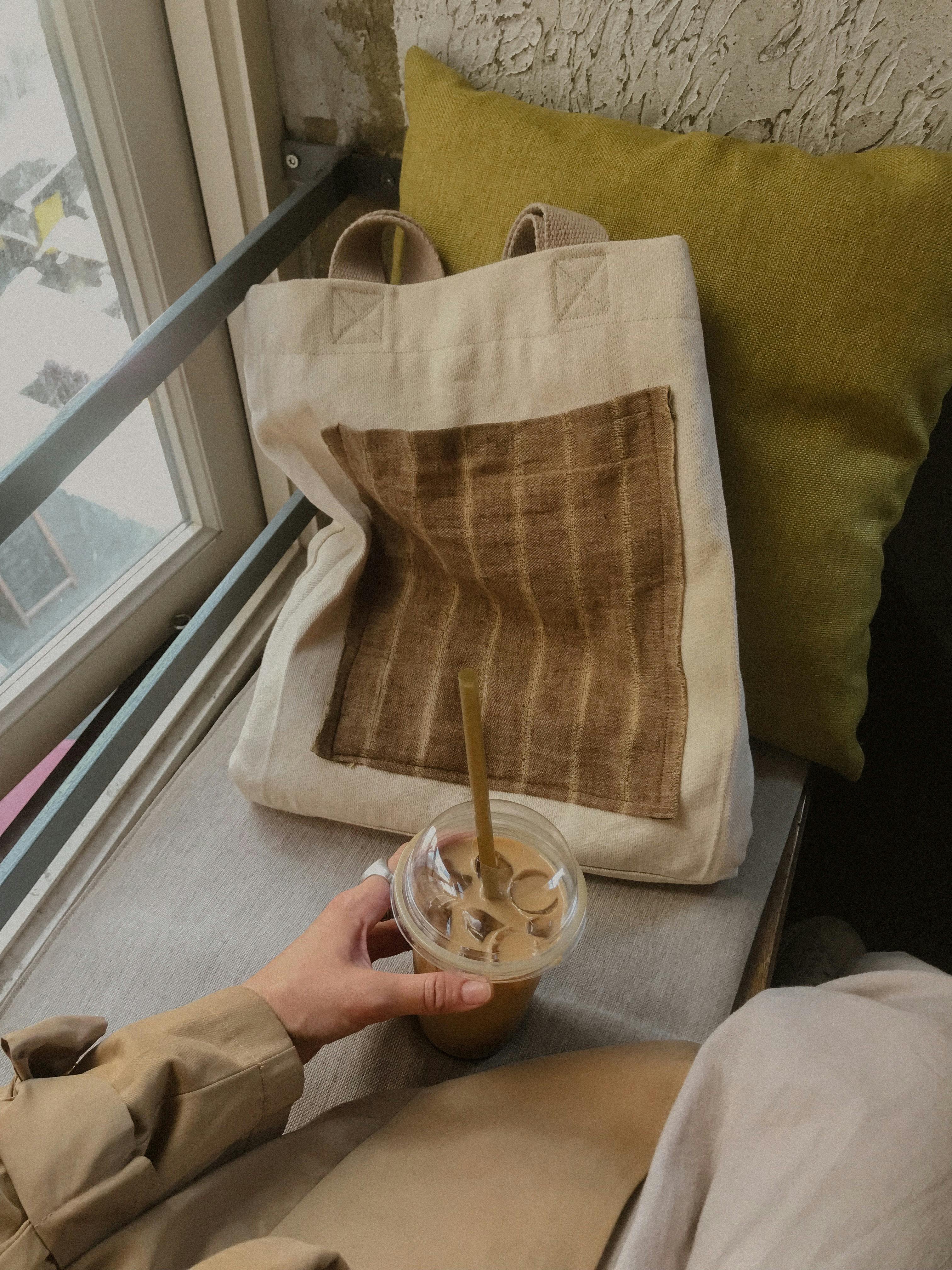 Point of View of a Person Holding an Iced Coffee near a Tote Bag · Free ...