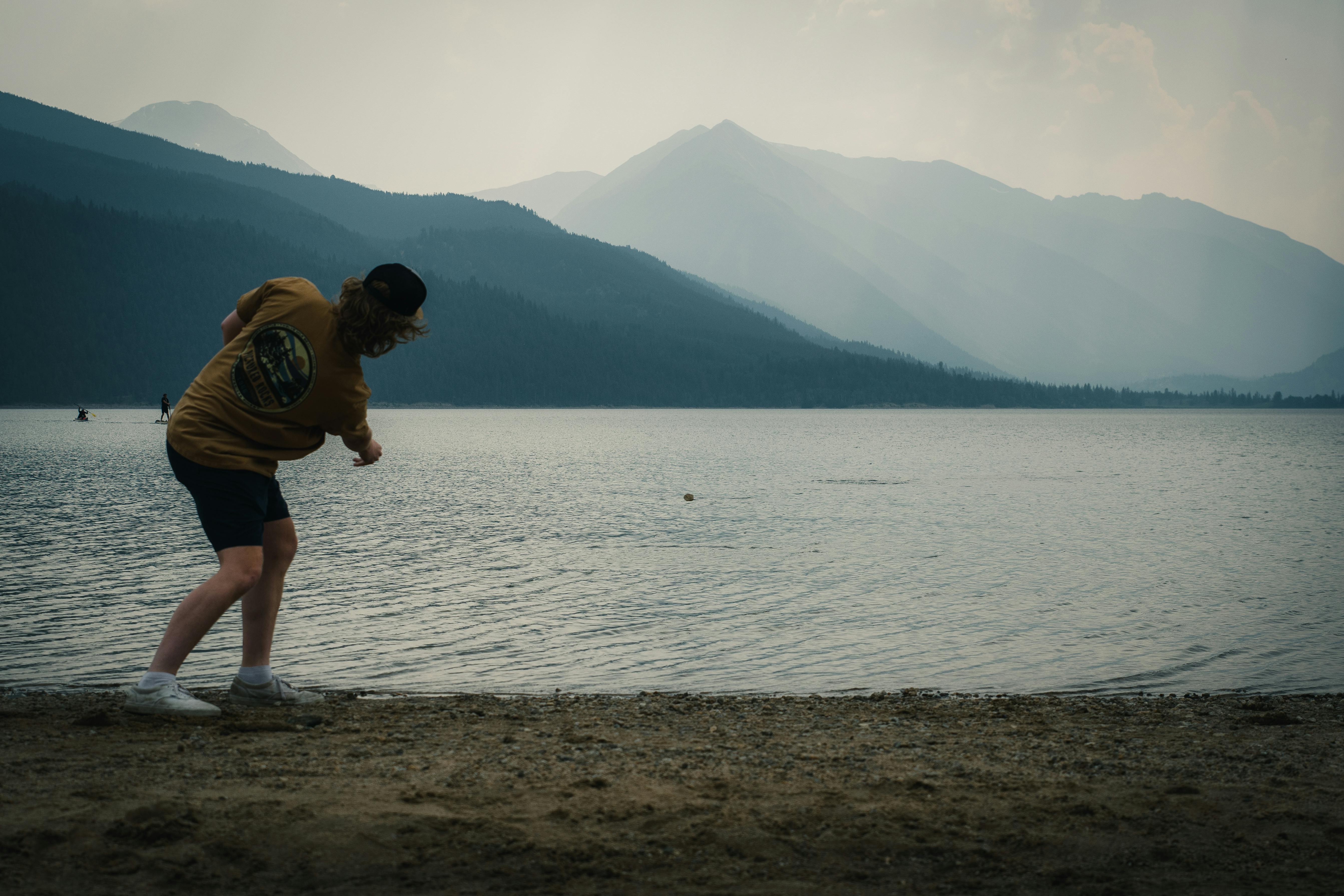A Person Throwing a Stone in the Beach · Free Stock Photo